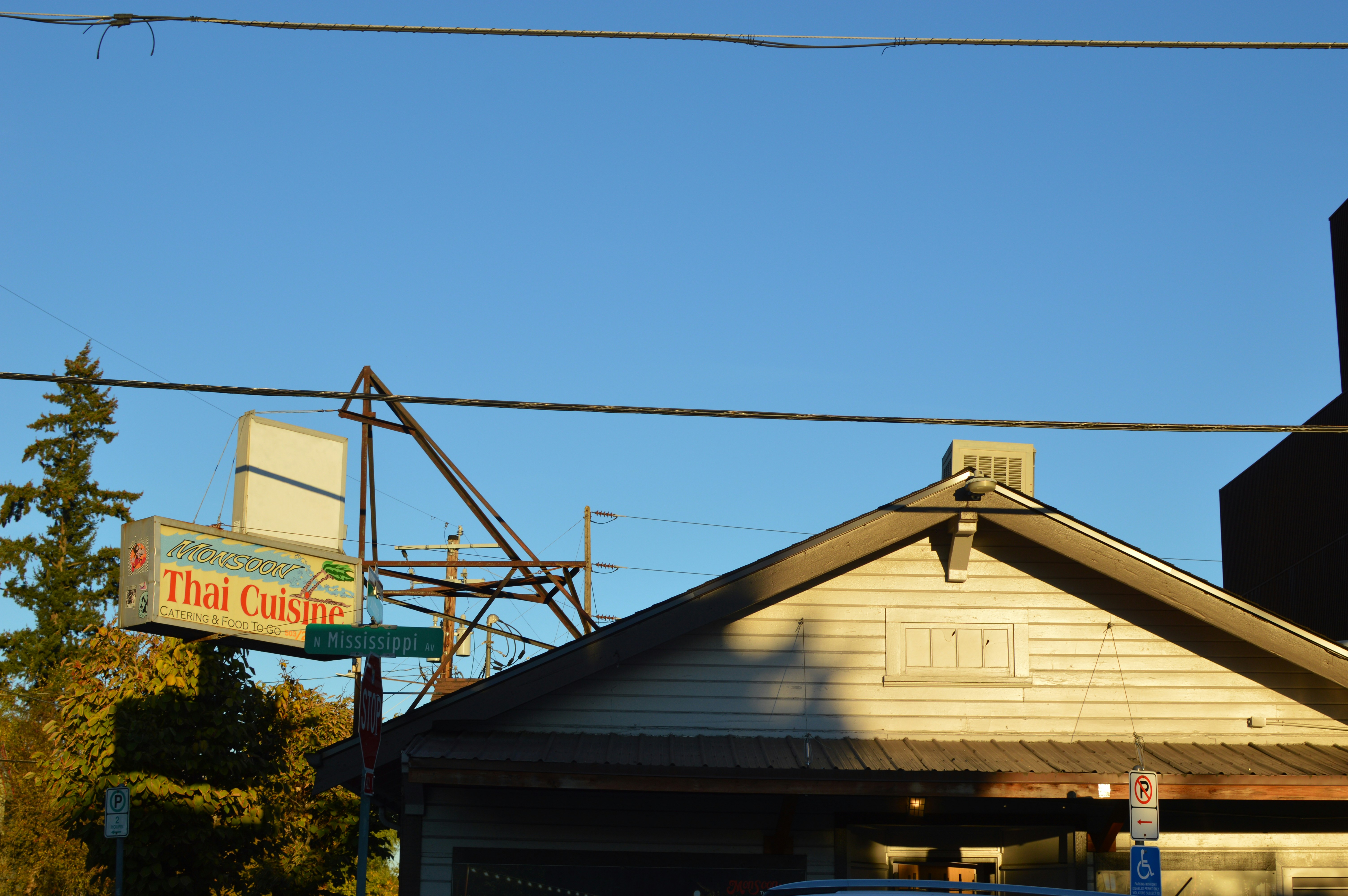 Thai Sign Overhang: Urban Rooftops Meet Clear Sky
