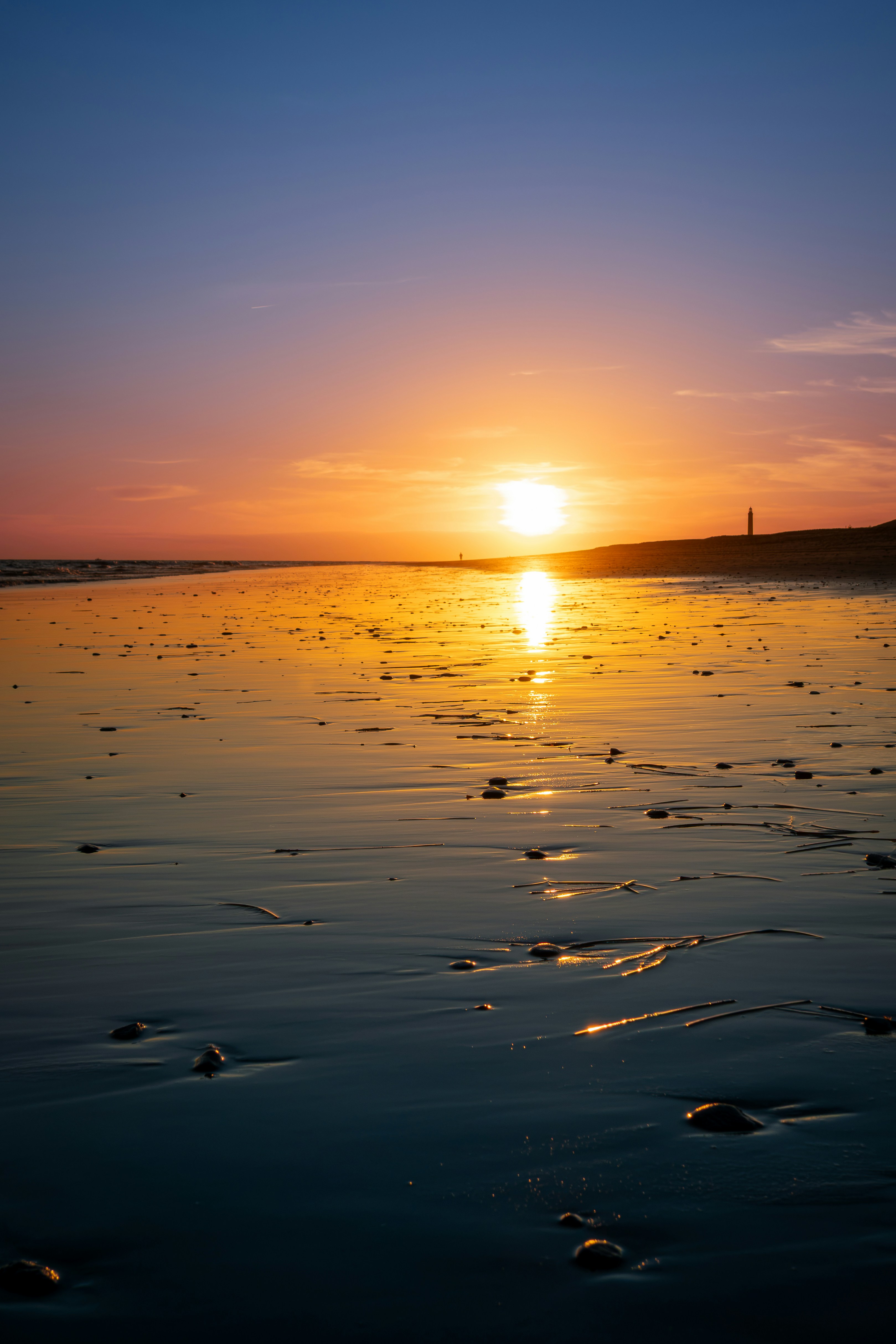 Silhouette of a Coastal Sunset: Quiet Tide Reflects the Sky