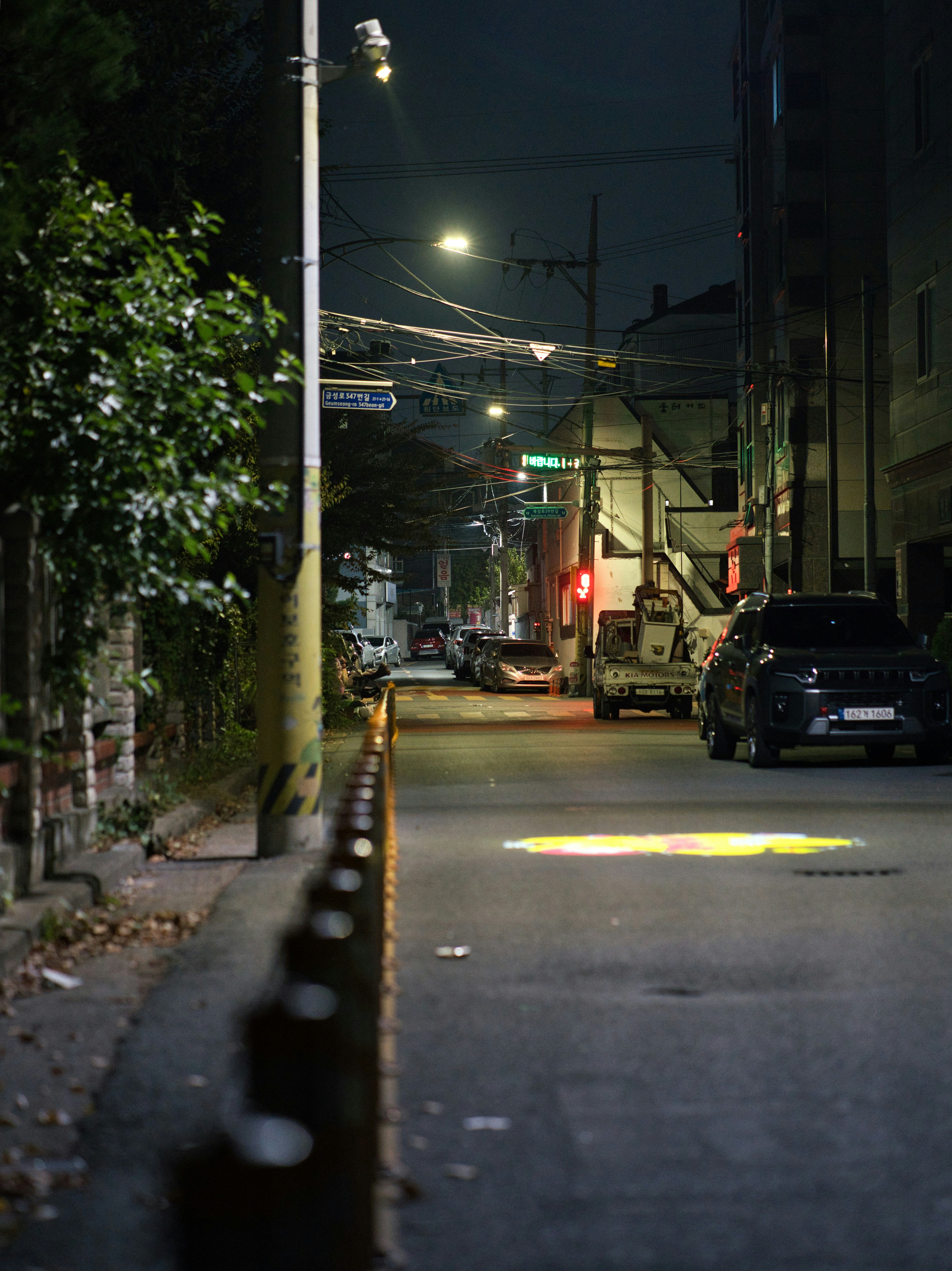 Night in the Side Street: Neon, Railings, and Quiet Traffic