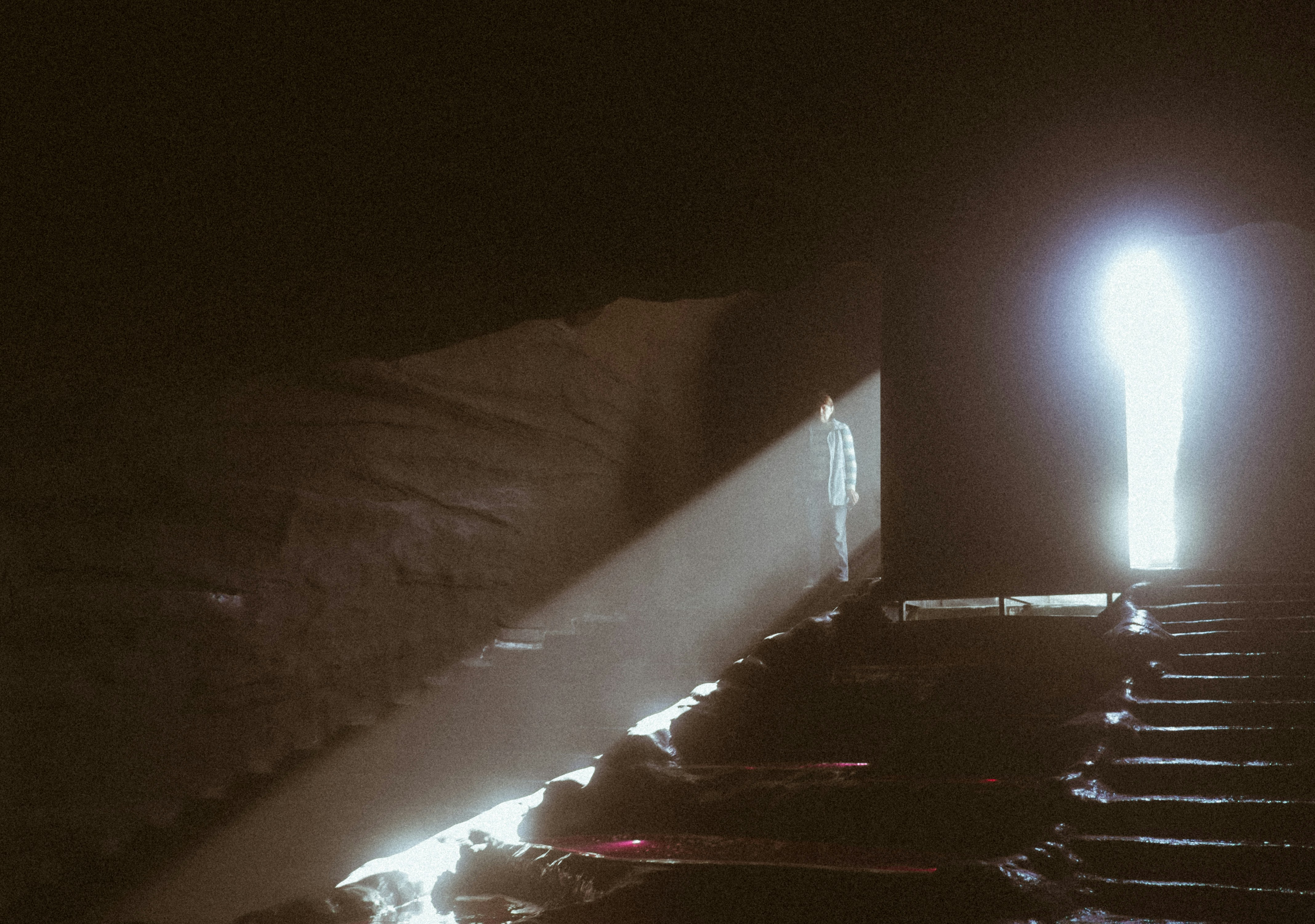 Beacon in the Cave: A Single Figure in Ray-lit Quiet