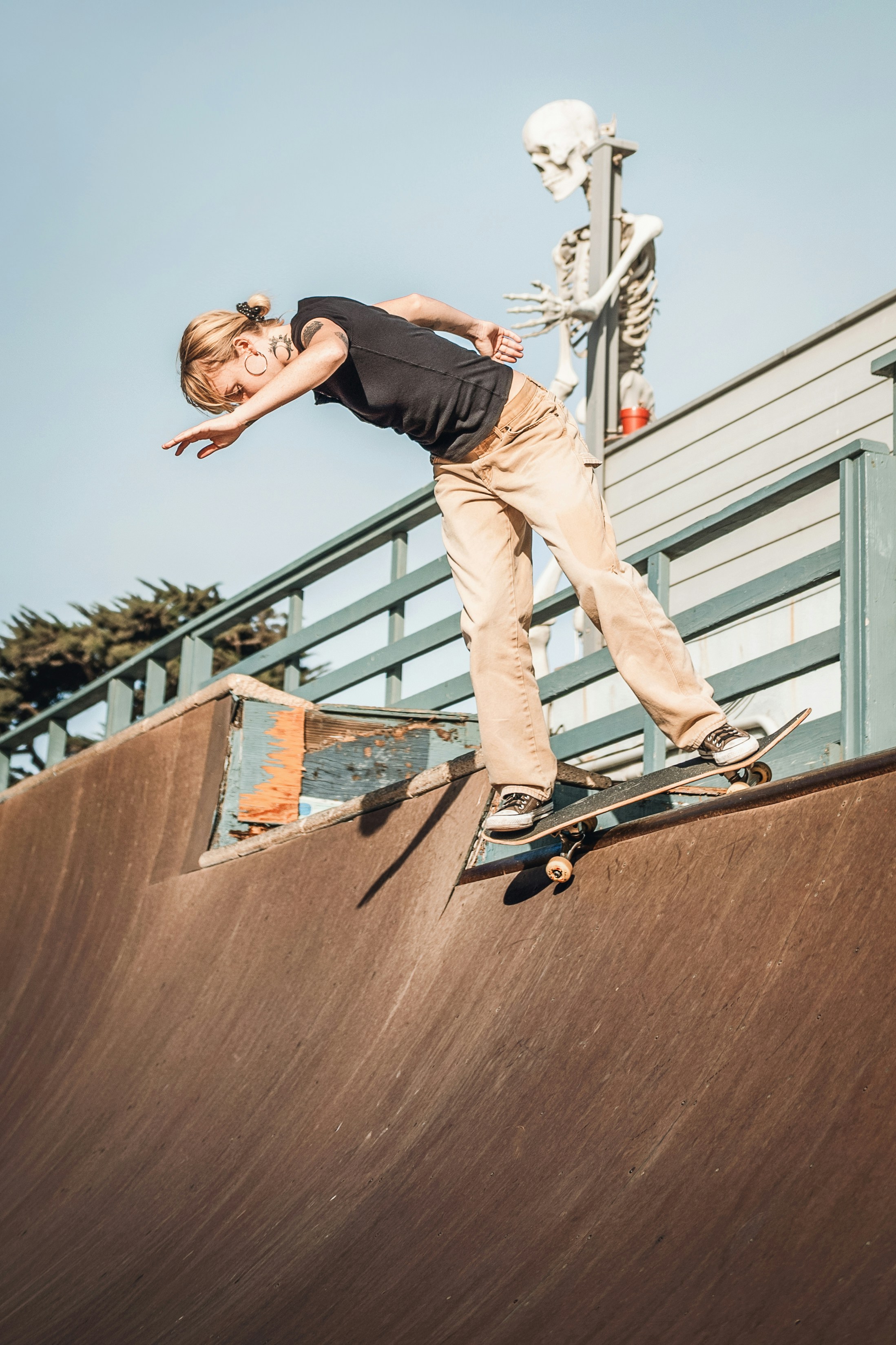 Skater in Mid-Flight on a Ramp Under a Skeleton Sculpture