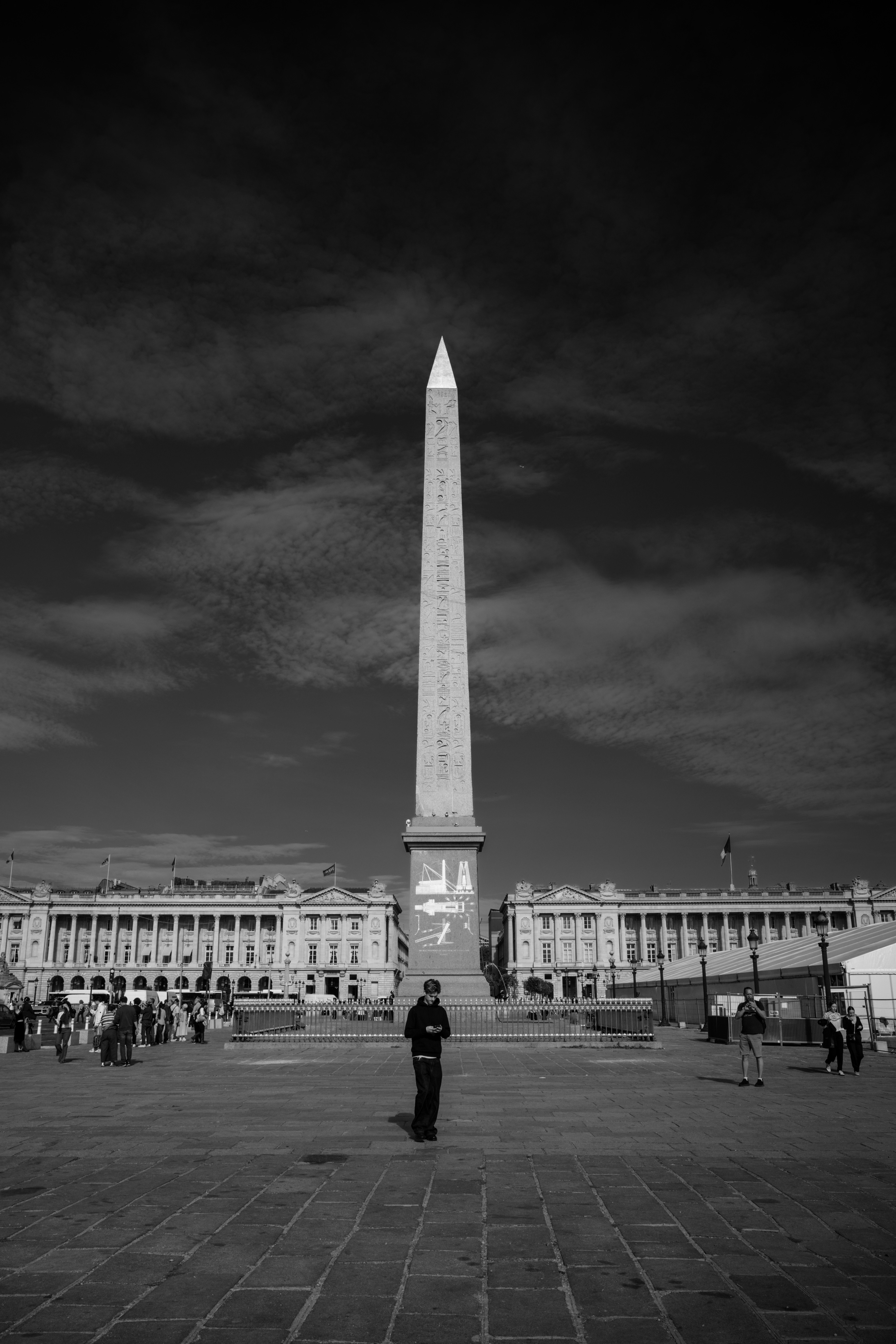 Centered Obelisk Under Dramatic Sky in a Wide Plaza