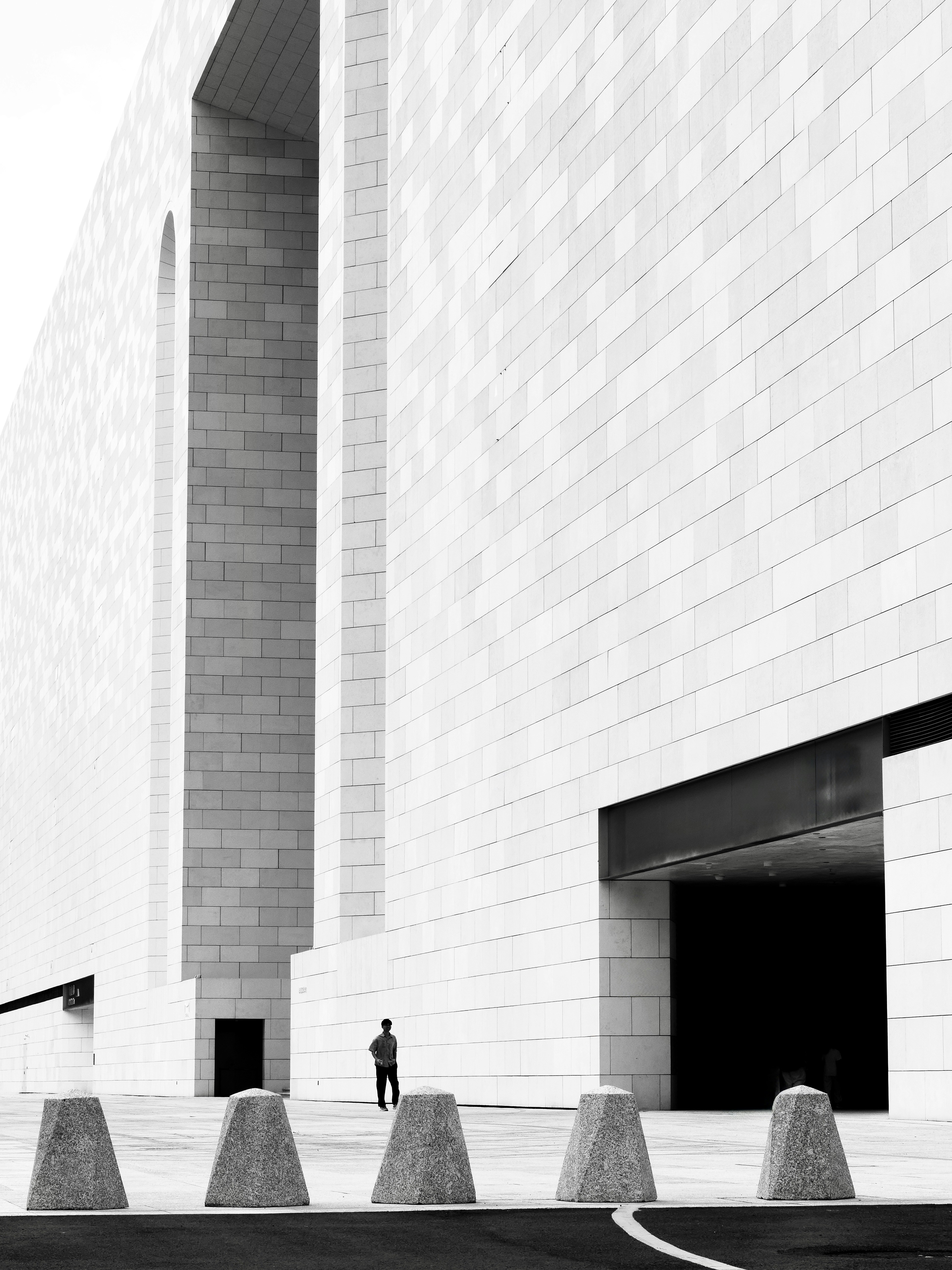 Solitary Figure at the Edge of Monolithic Facade