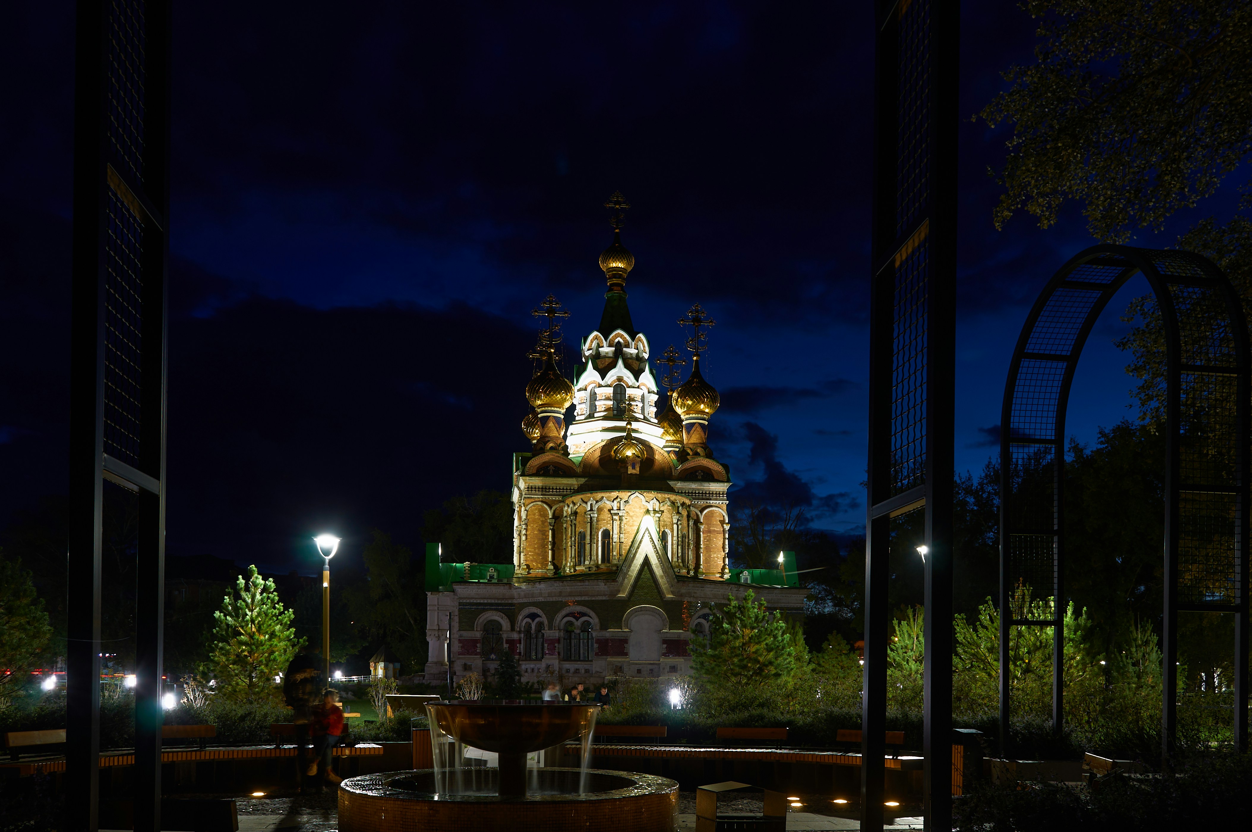Illuminated Cathedral Framed by Night Garden Archway