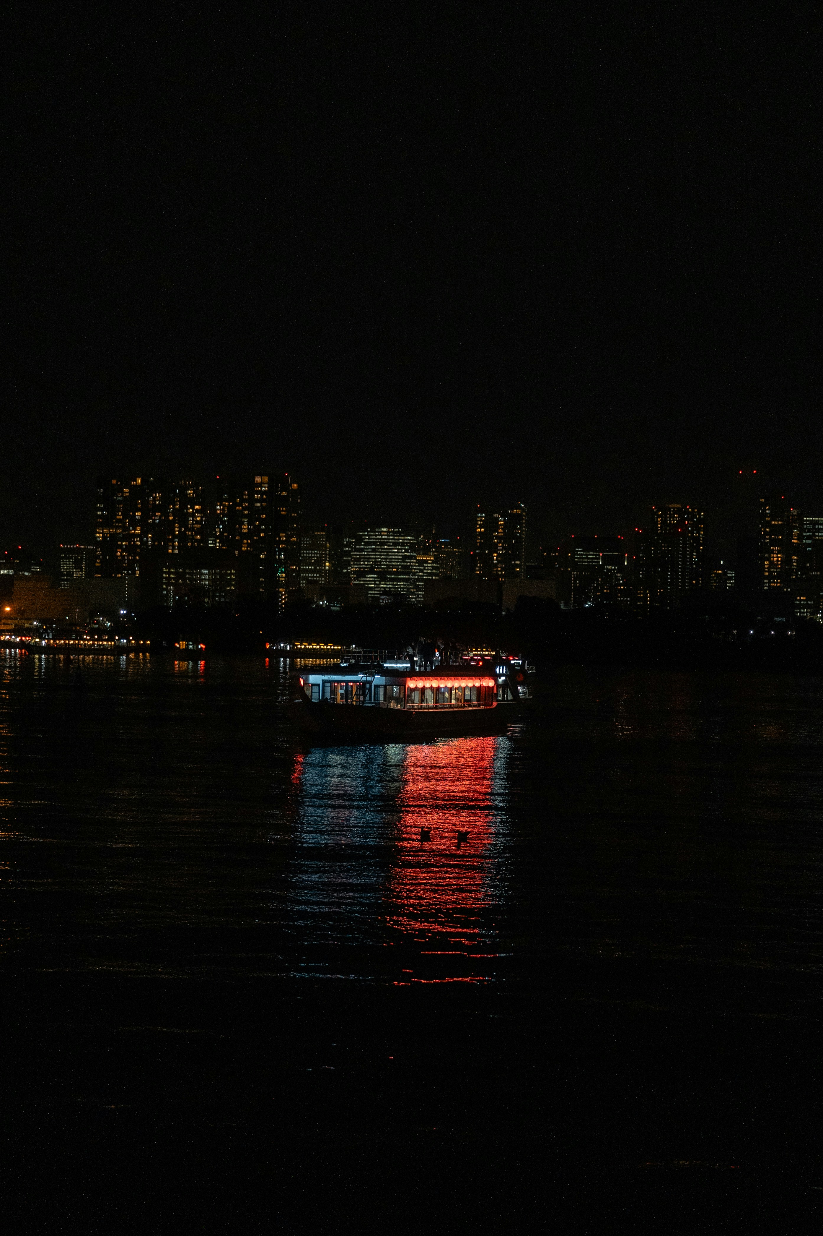 Night Vessel on a Quiet River: Neon Reflections Under City Lights