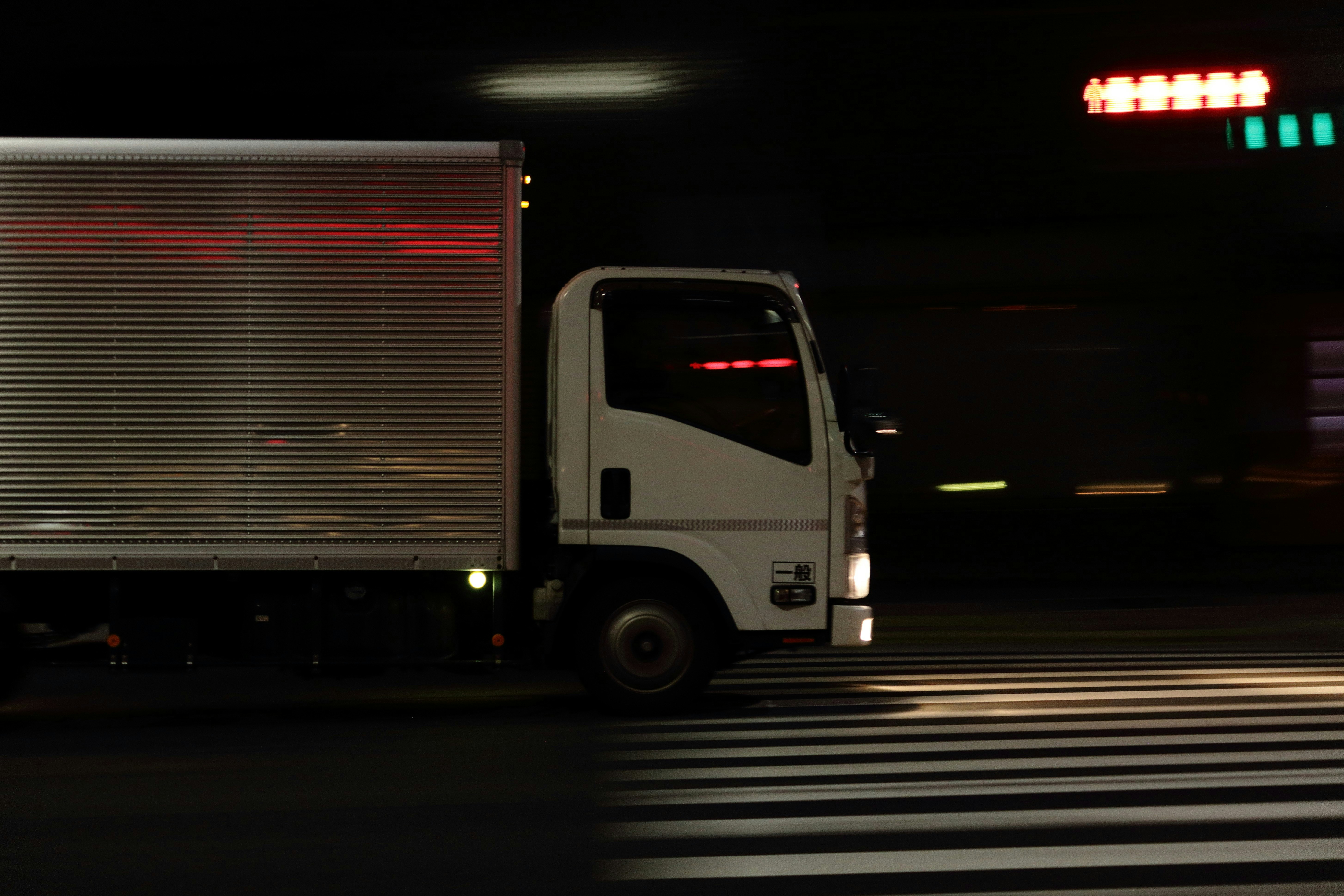 Night Courier in Motion: Headlights Blurring Across a Crosswalk