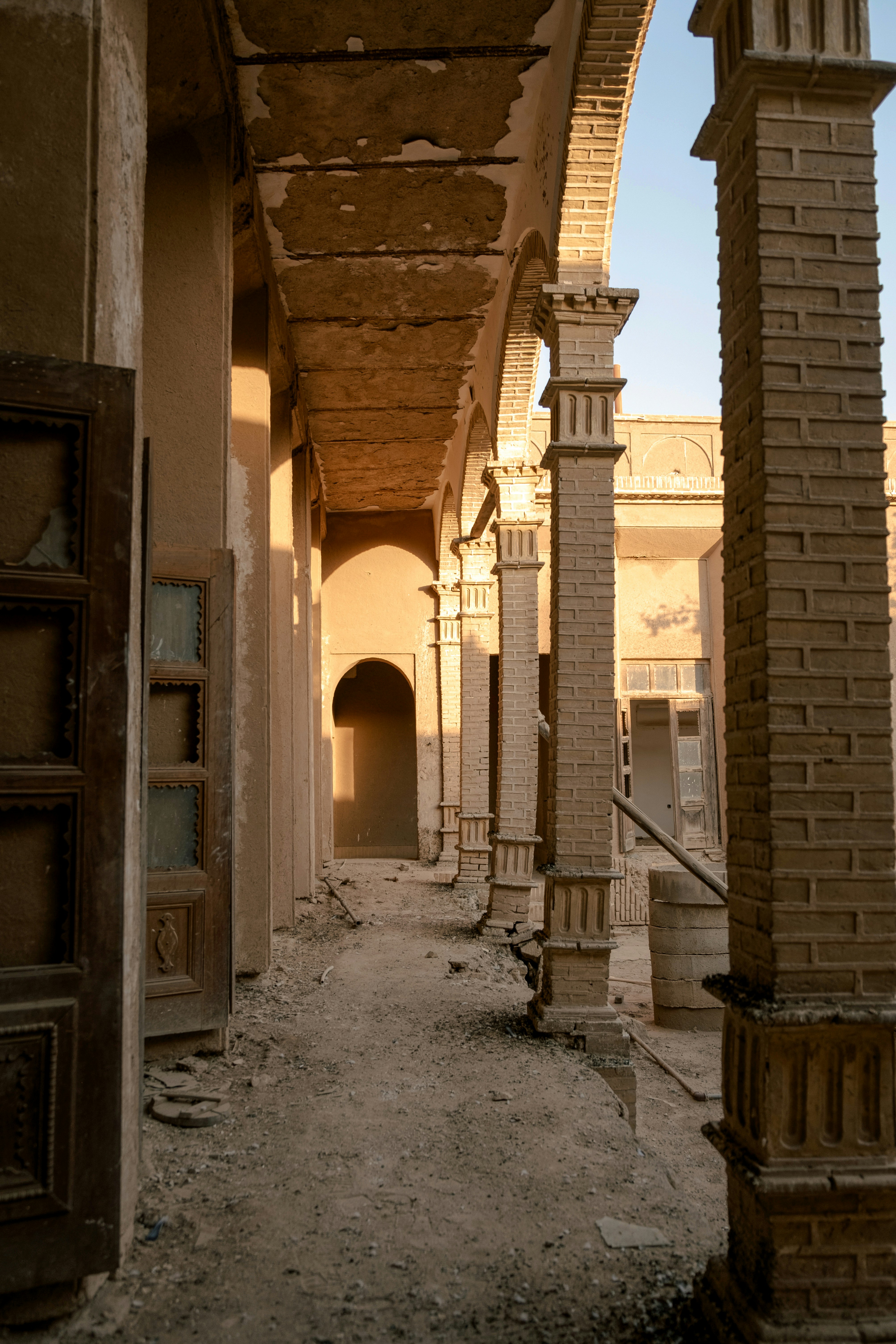 Sunlit Archway Corridor in an Ancient Brick Dialogue