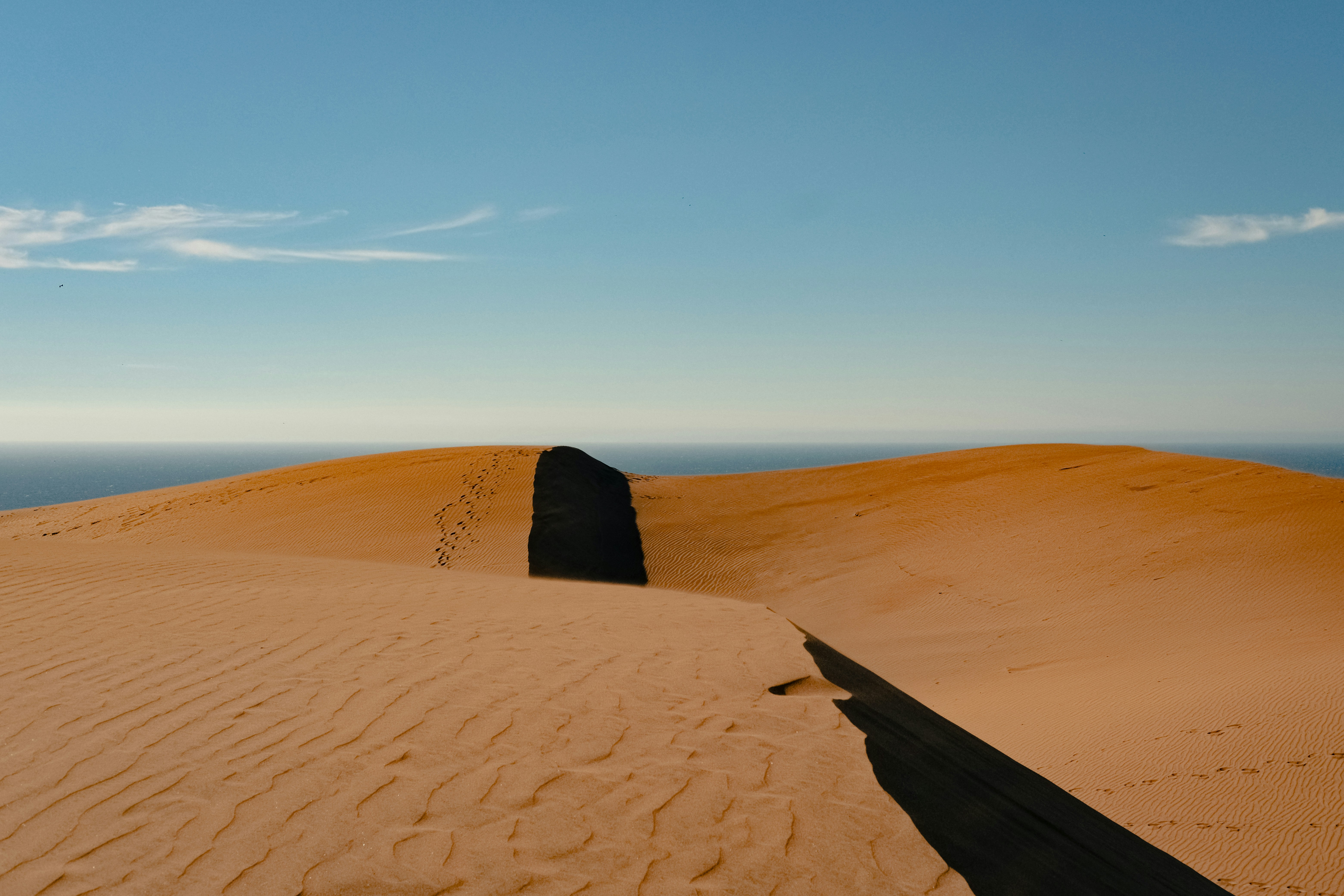 Shadowed ridge: a solitary dune split by a dark crevice