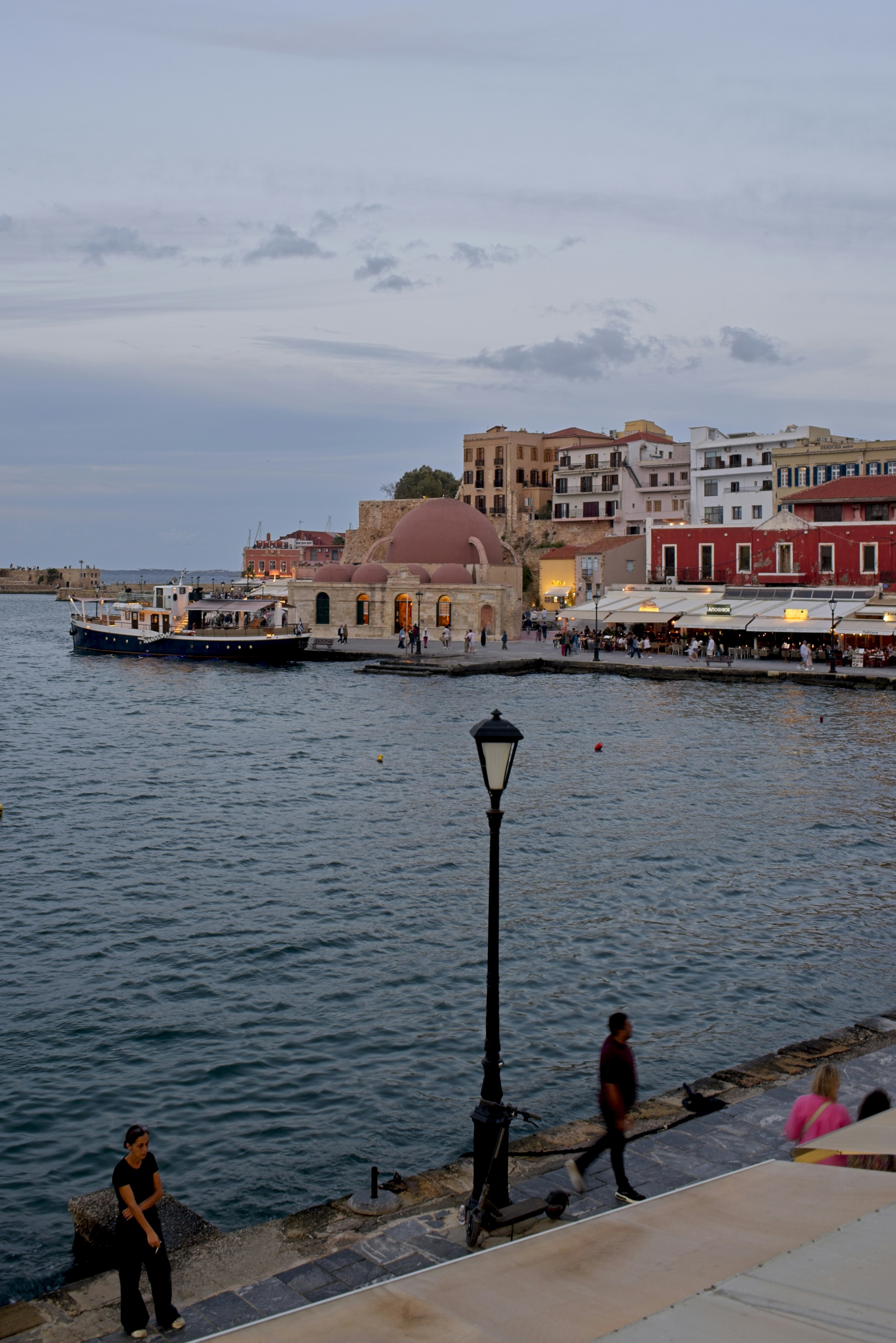 Harbor Arcades at Dusk: Stones, Lights, and Sea