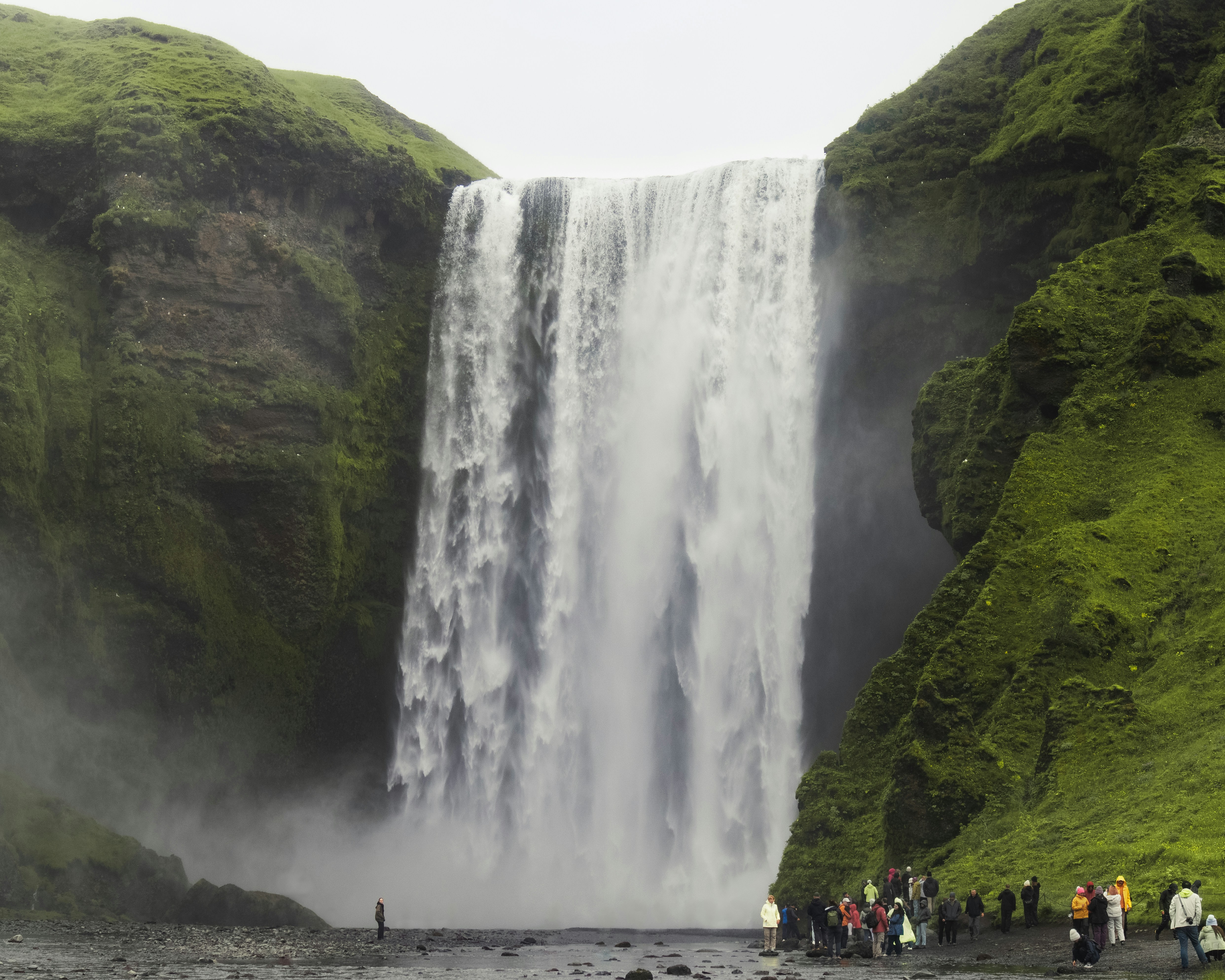 Veil of Water: A Towering Cascade Against Verdant Cliffs