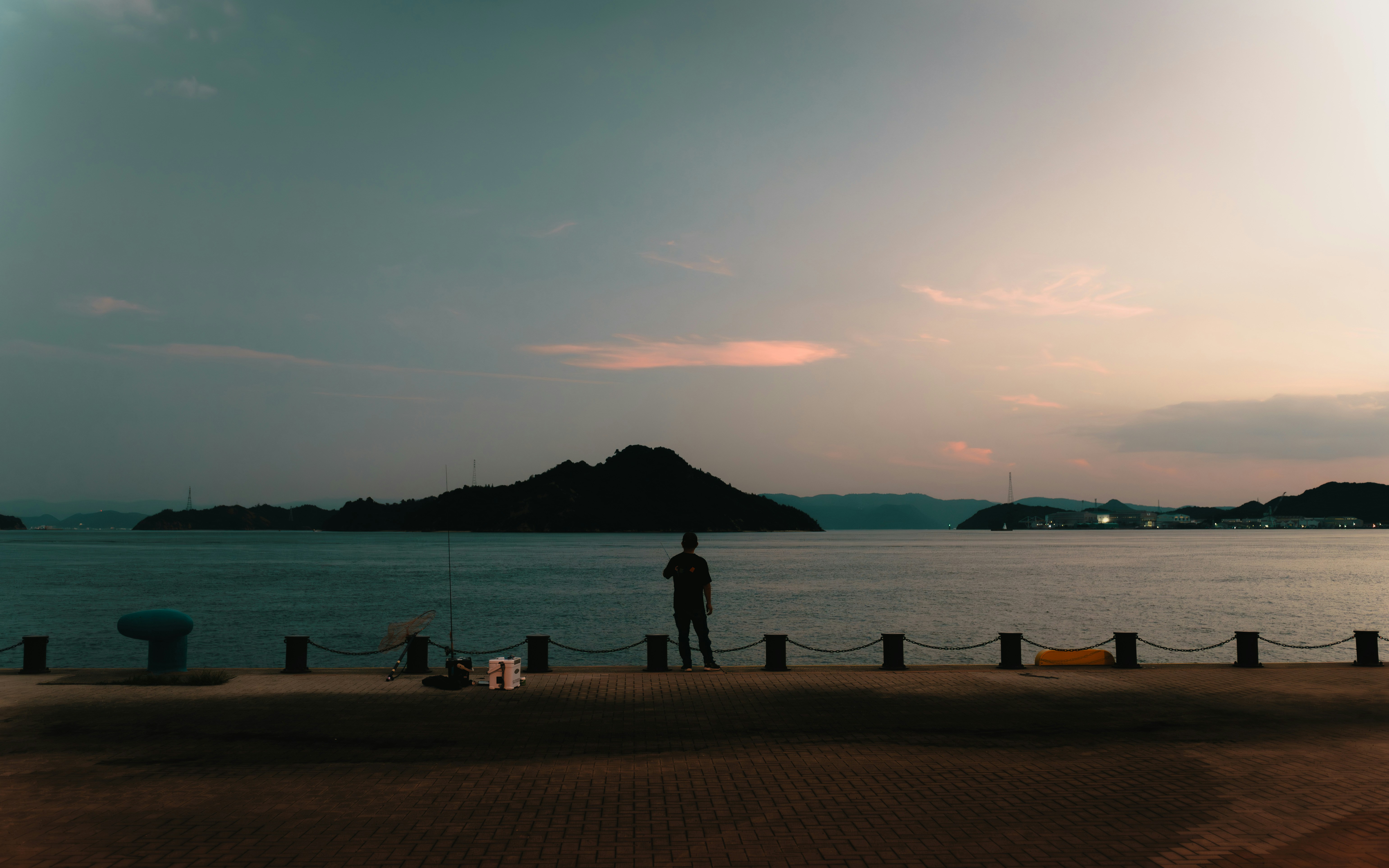 Silhouette at Dusk: A Lone Figure by the Waterfront