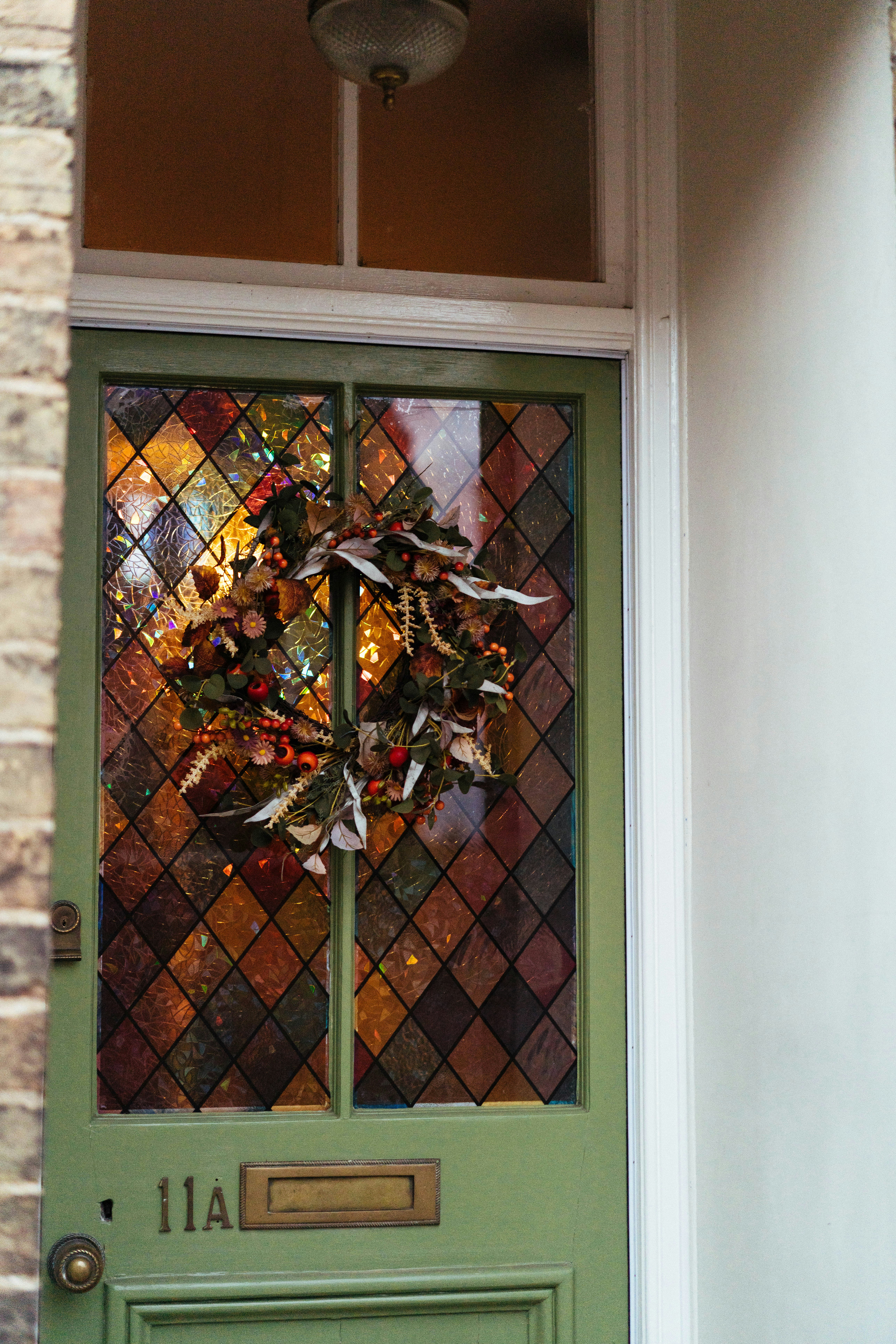Wreath on a Green Front Door Framed by Diamond Glass