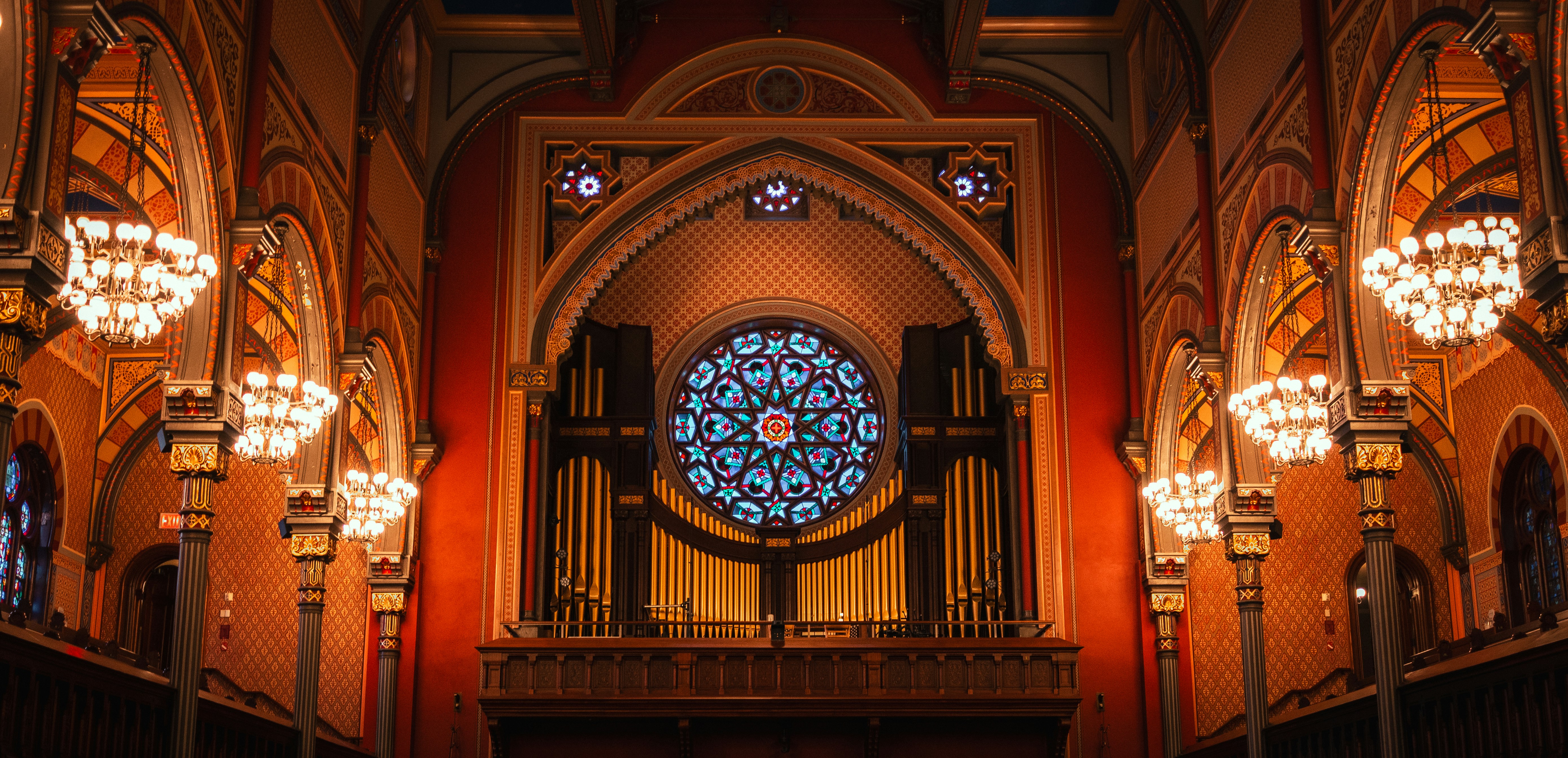 Circular stained-glass heart: organ loft above the ornate nave