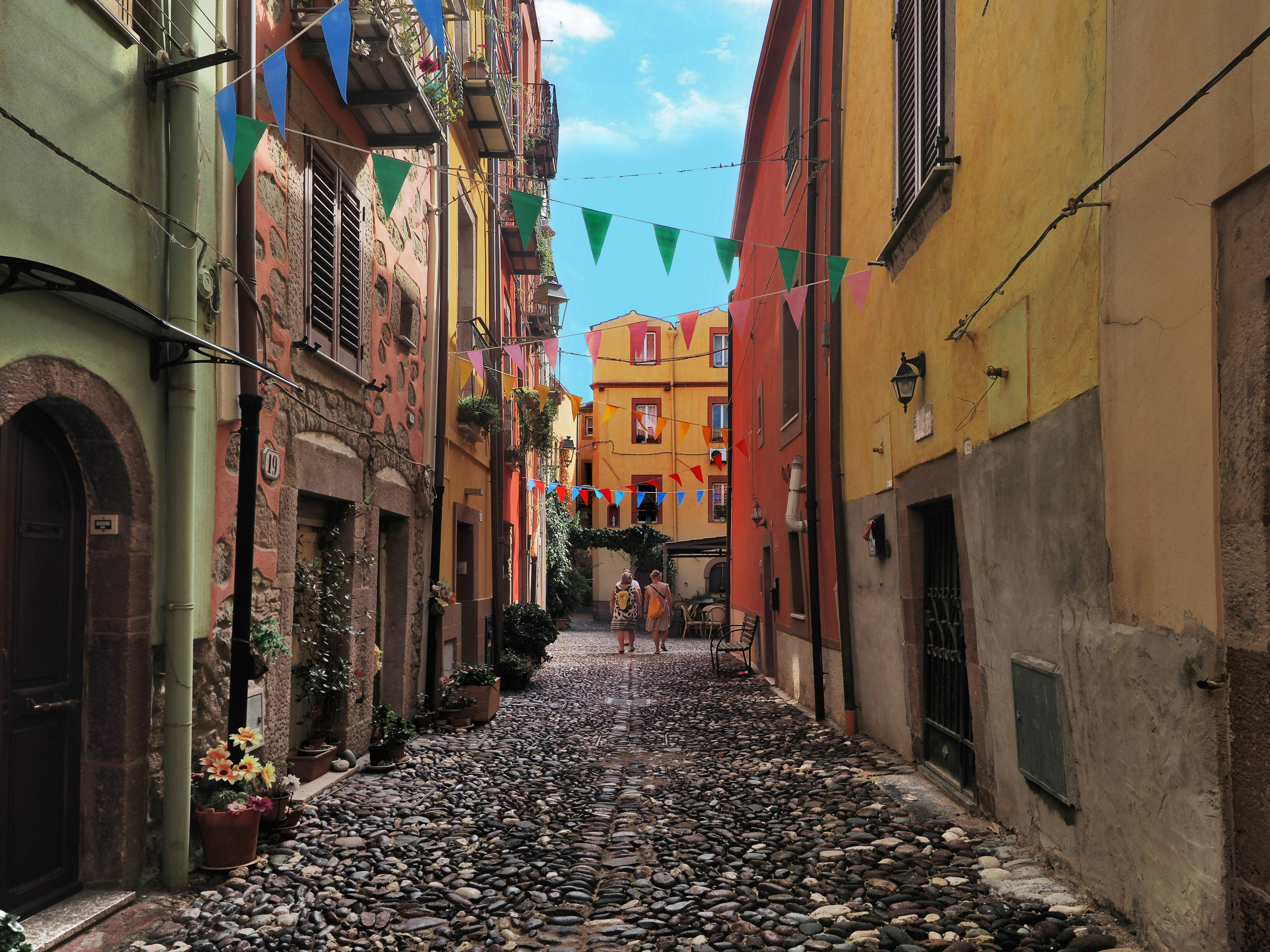 Colorful cobblestones and bunting: a sunlit alley in motion