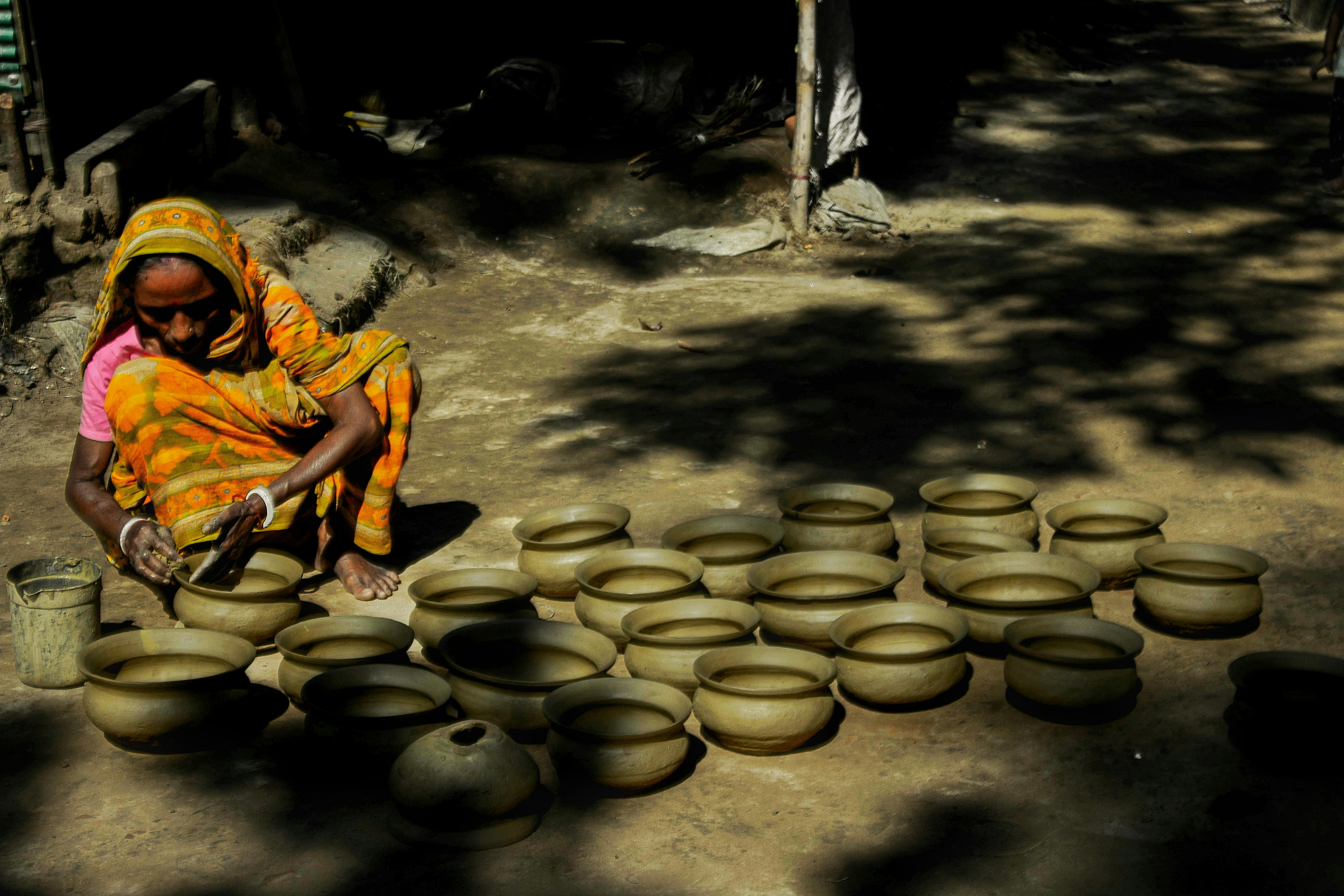 Hands in Clay: A Sunlit Market of Earthen Pots