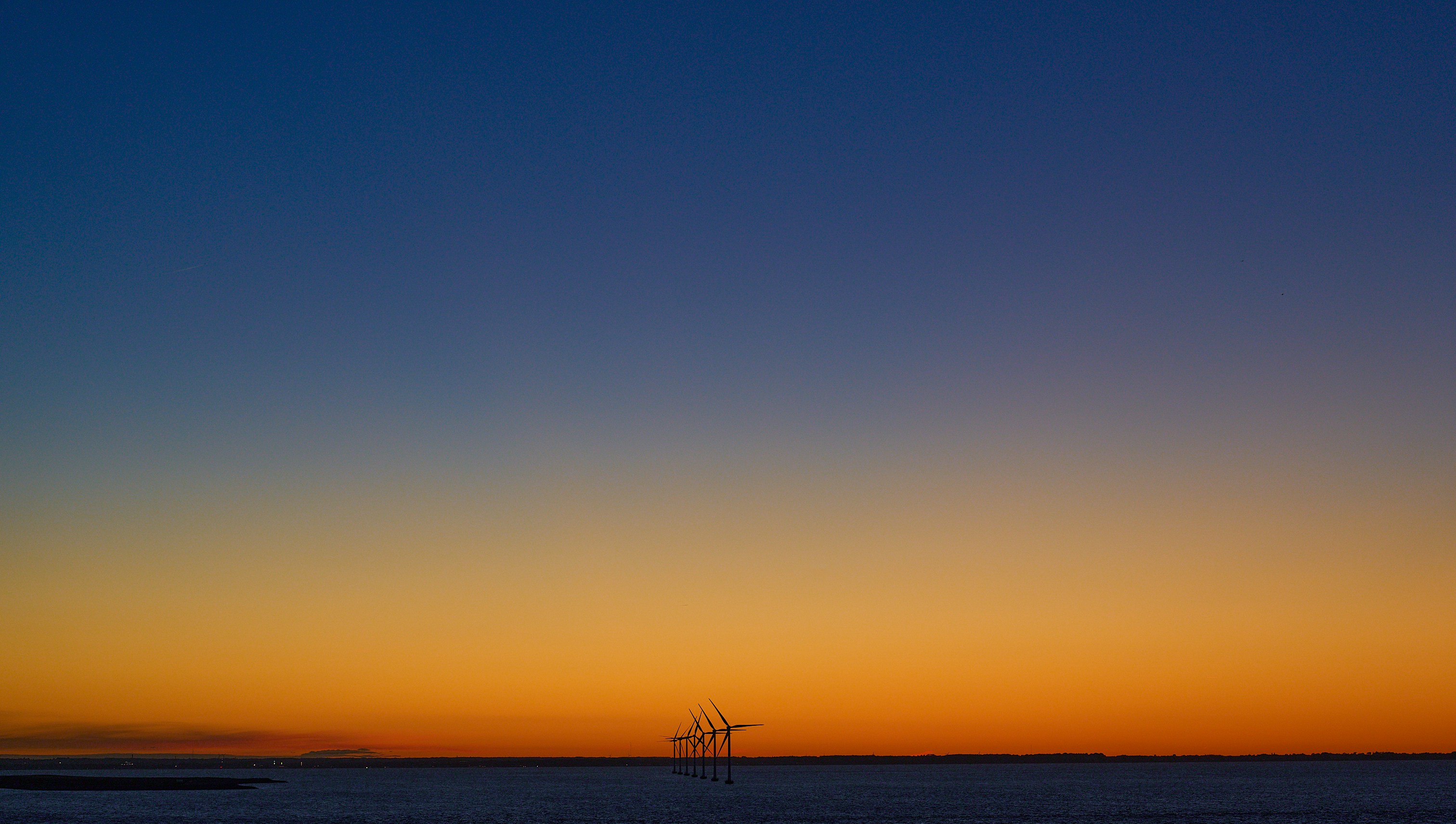 Horizon at Dusk: Silent Wind Farm on the Quiet Sea