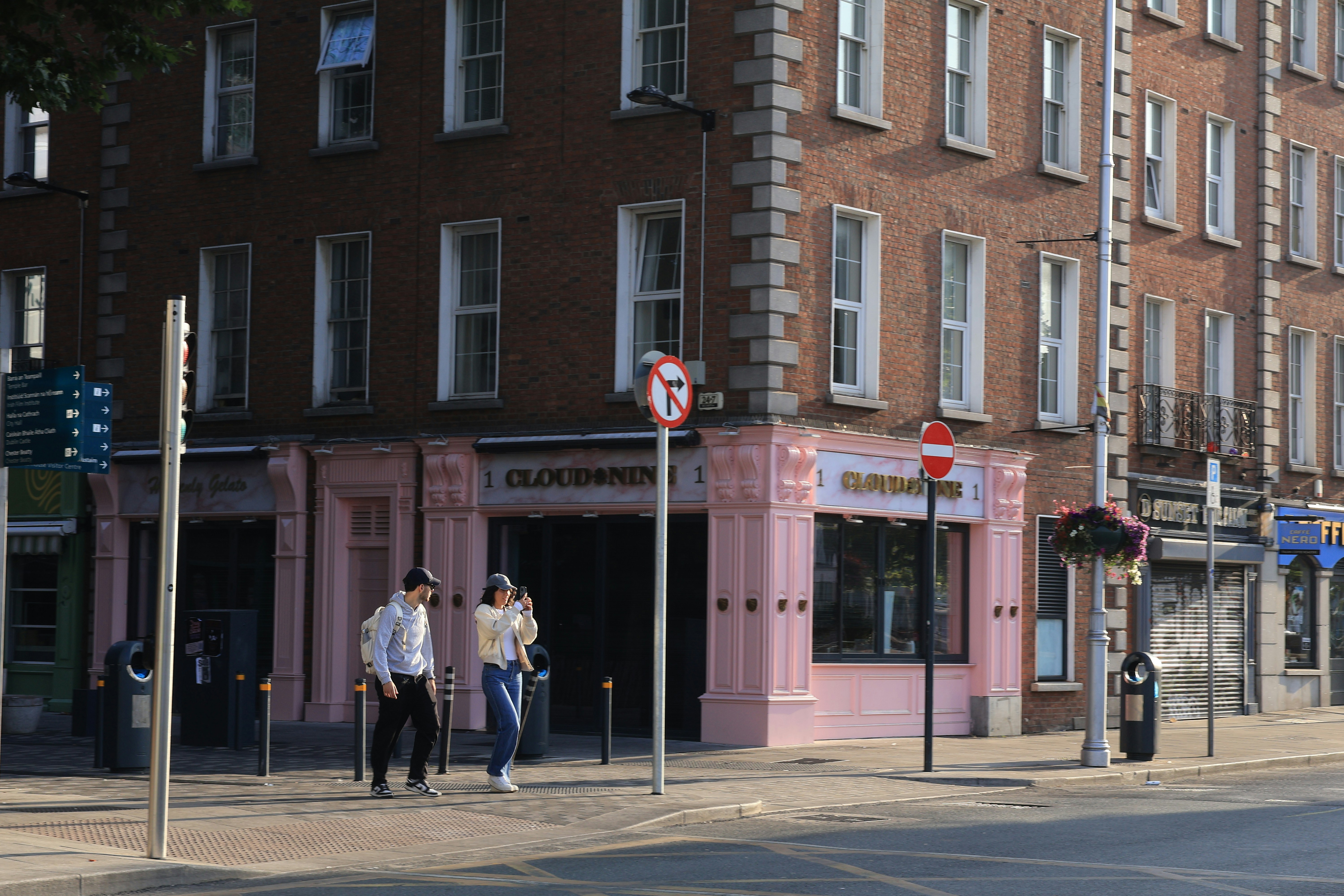 Pink Corner Café Faces the Street, People Crossing the Pedestrian Strip
