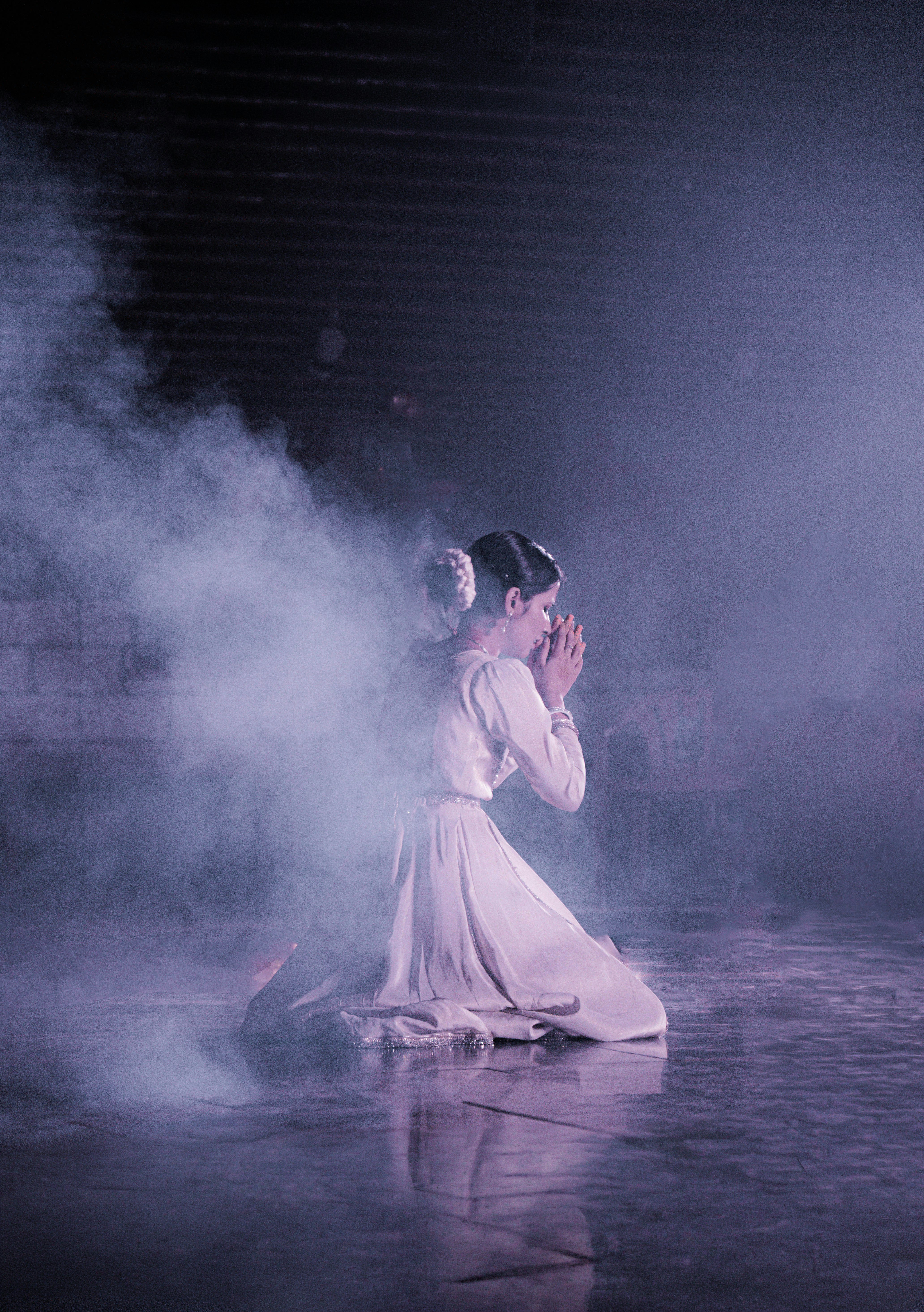 Kneeling Dancer in Smoke: A Quiet Moment Beneath Steam and Shadow