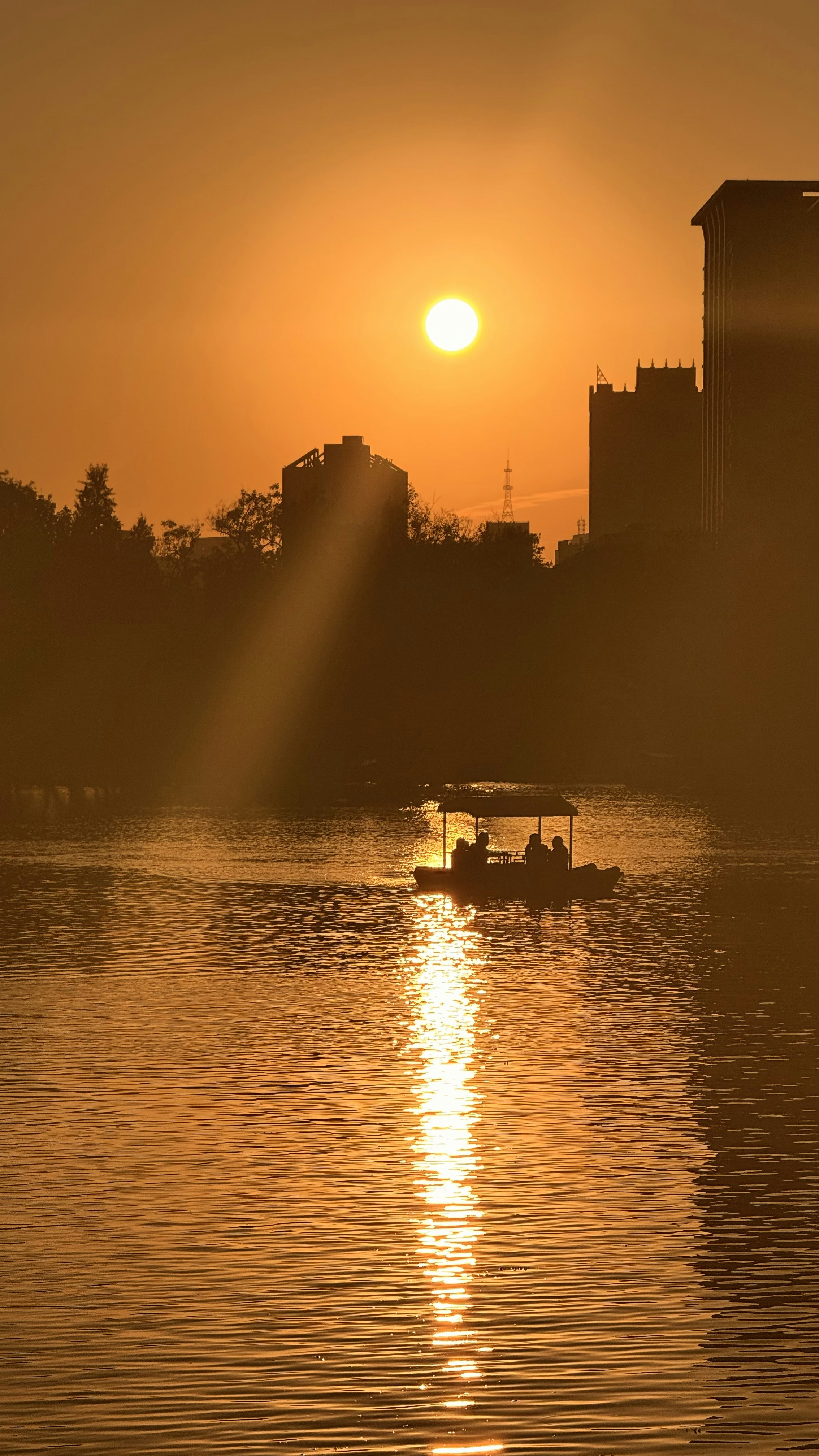 Sunlit Boat on a Quiet Urban River at Golden Hour