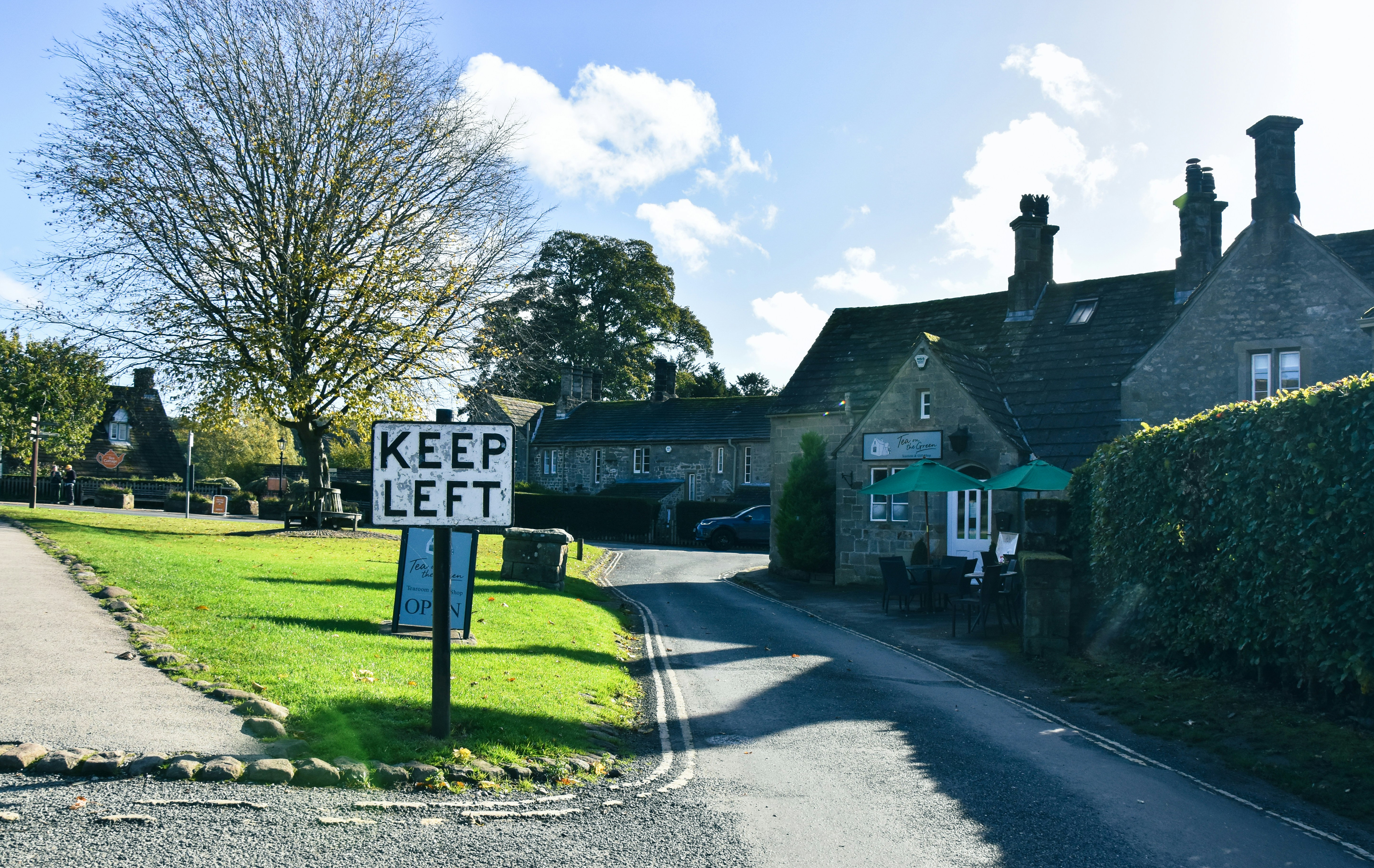 Keep Left, Keep Right: A Quiet Village Curve Beneath Blue Skies