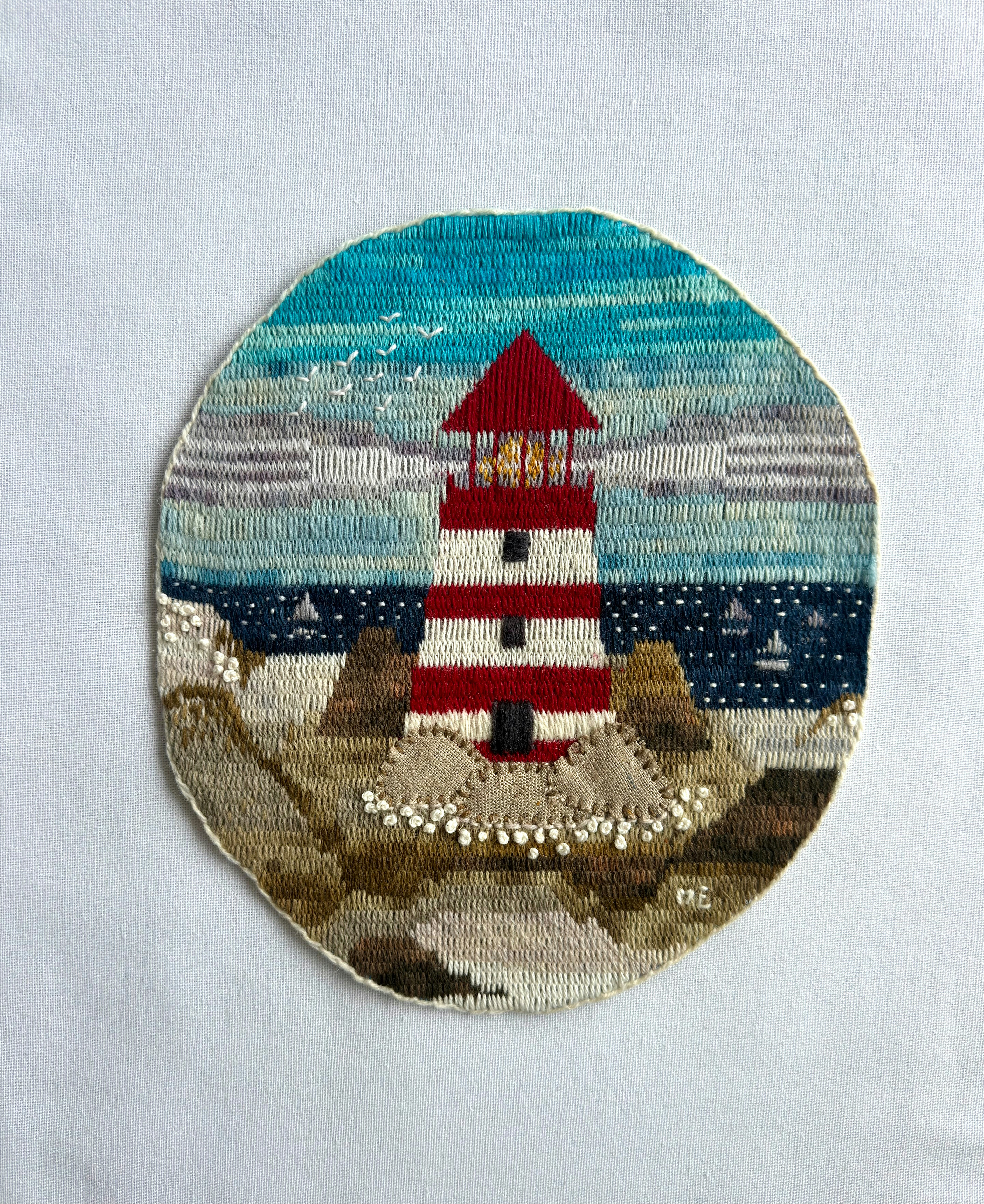 Embroidered Beacon: A Red-and-White Lighthouse Amid Quiet Coastline