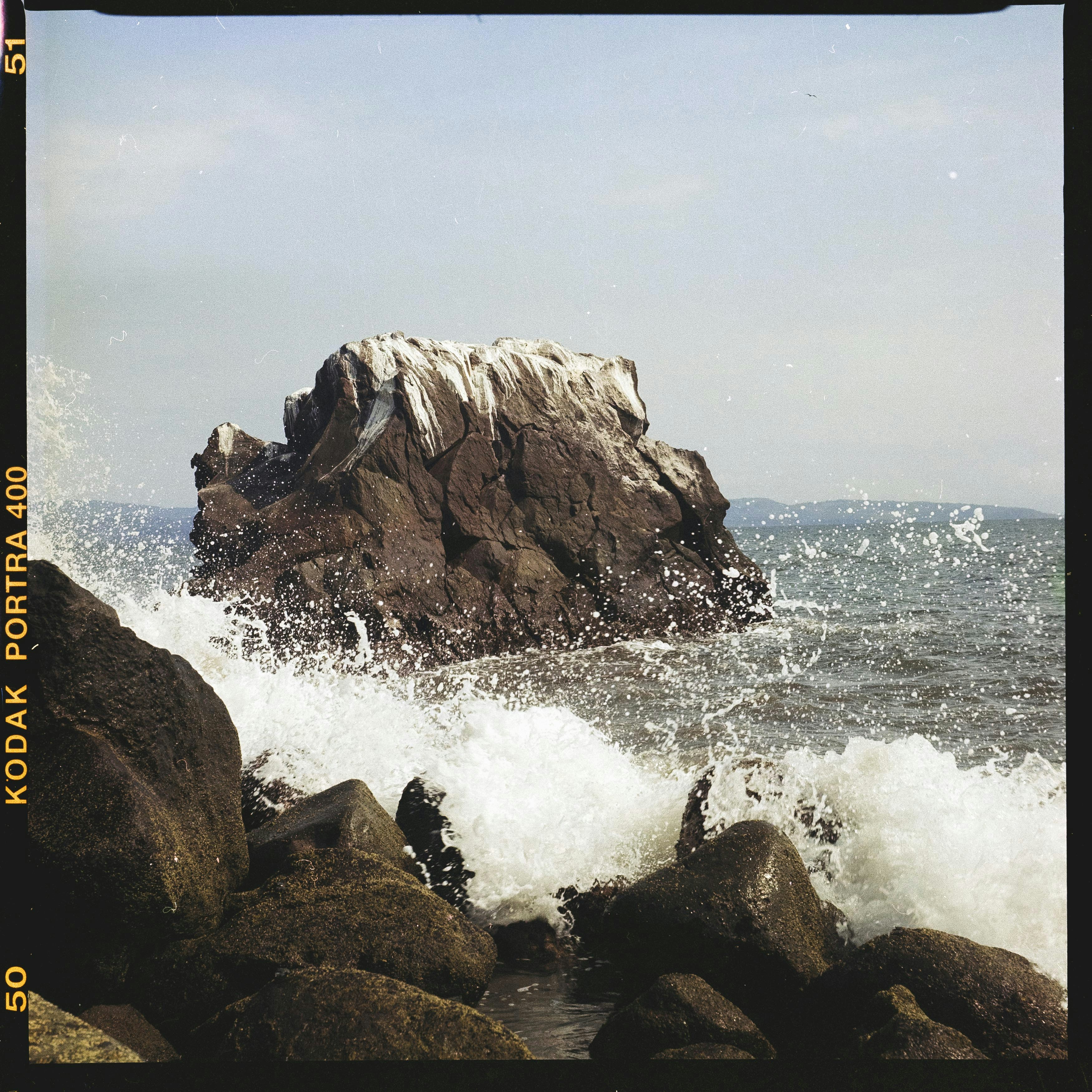 Seafoam Sentinel: A Rugged Rock Rising from Breaking Waves