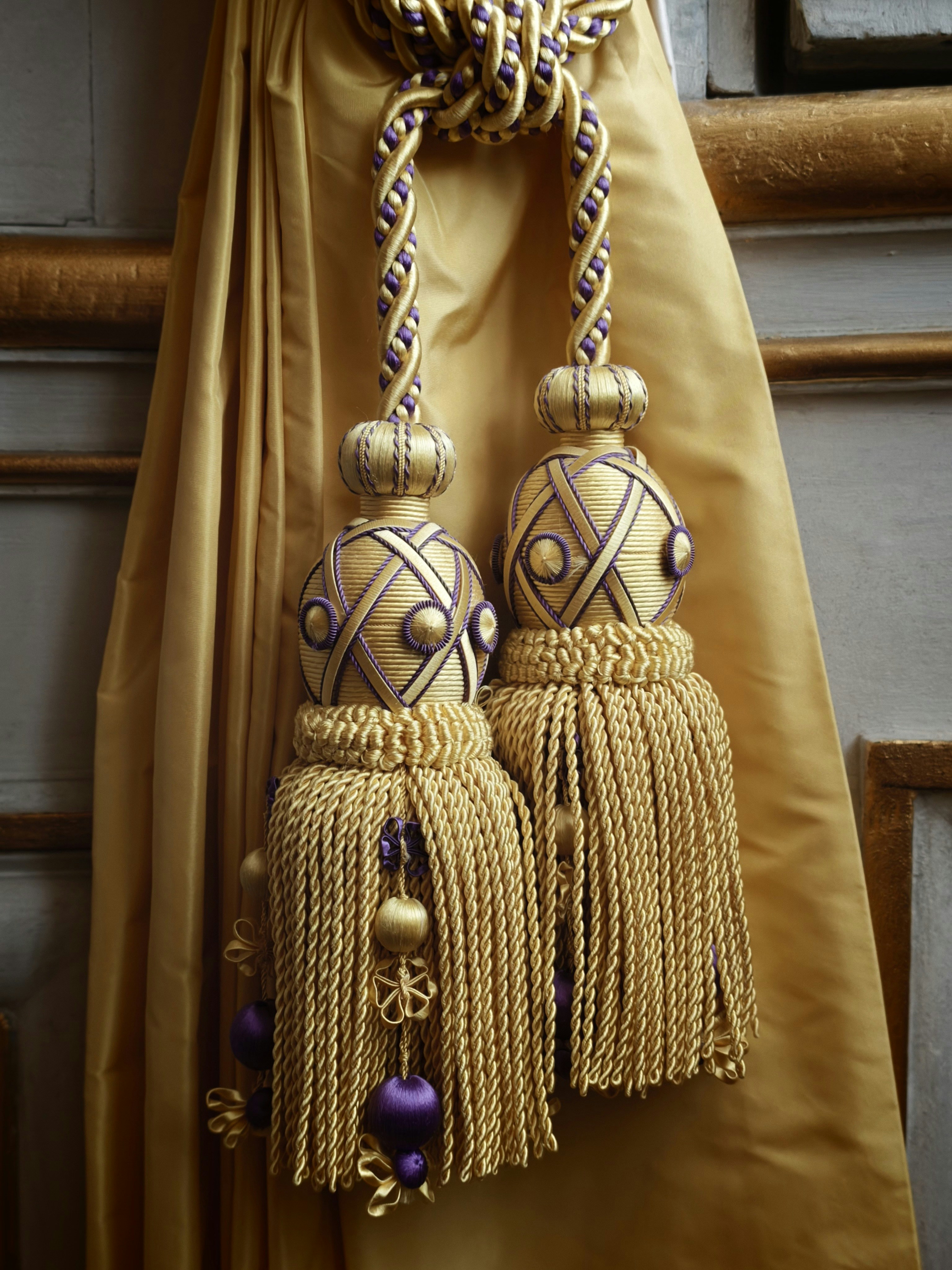 Luxurious gold tassels and rope adornment against a ceremonial backdrop