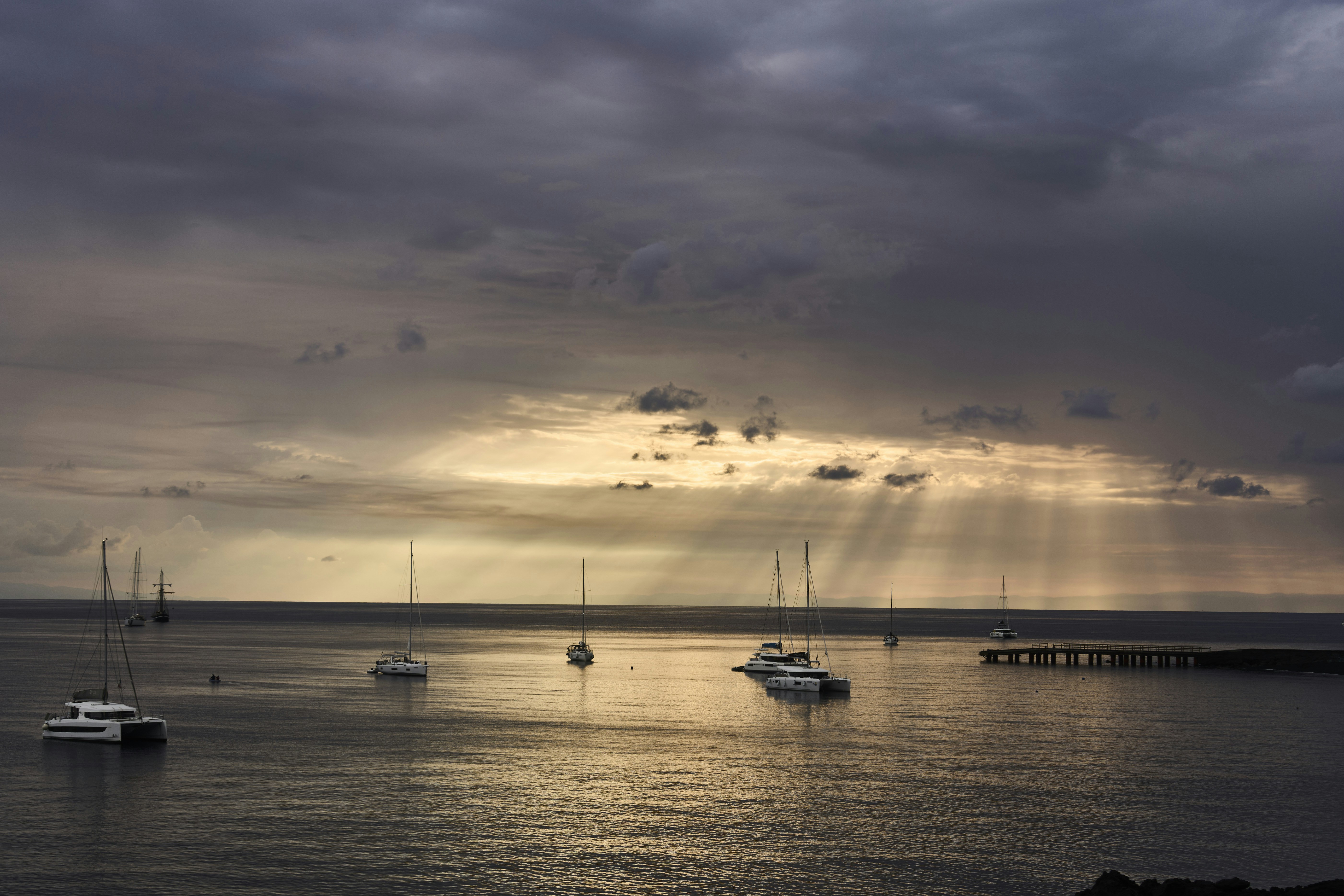 Sunbeams Through Clouds Illuminate Quiet Marina