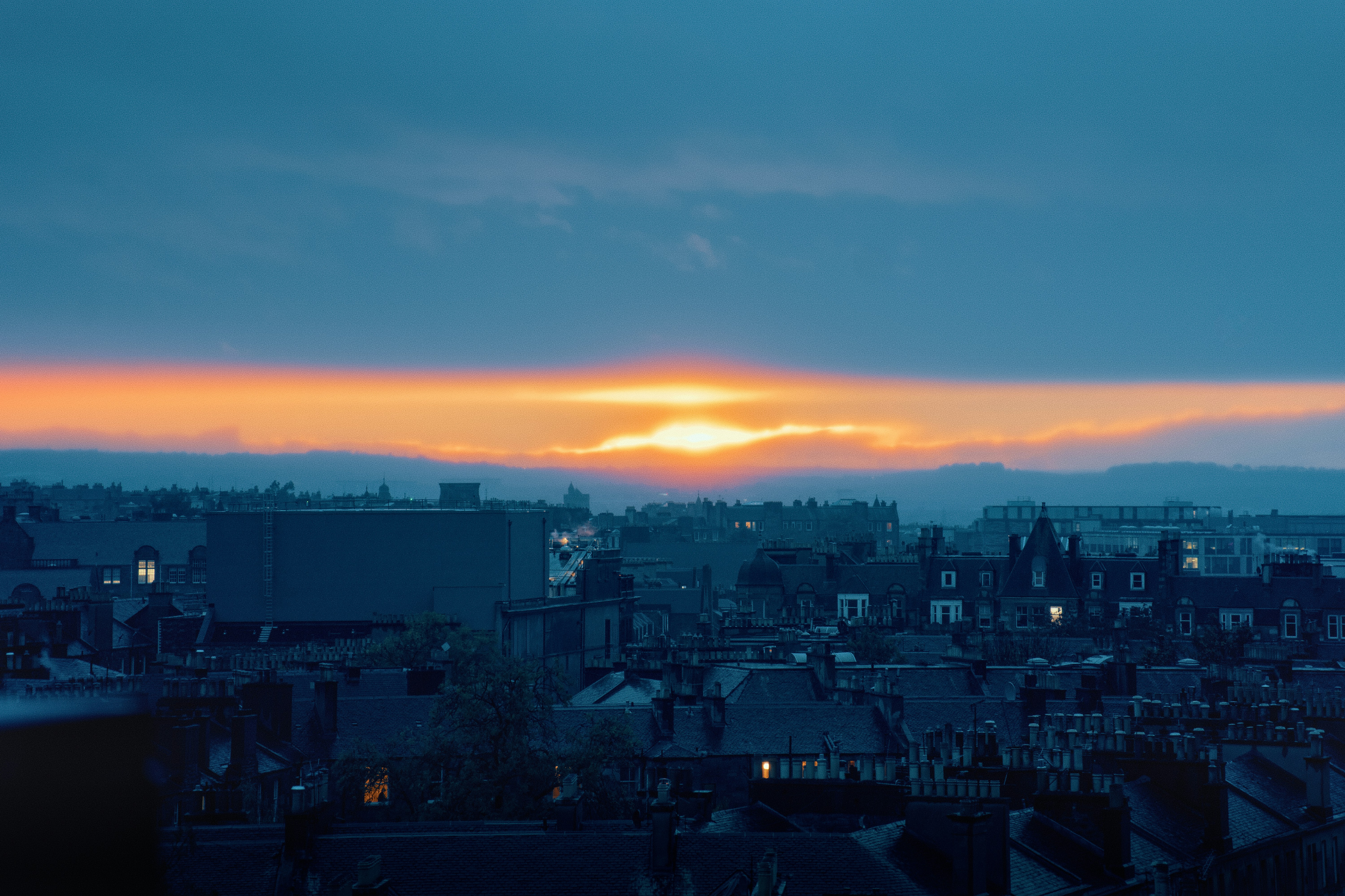 Dawn Slip Between the City Silhouette and a Narrow Sun
