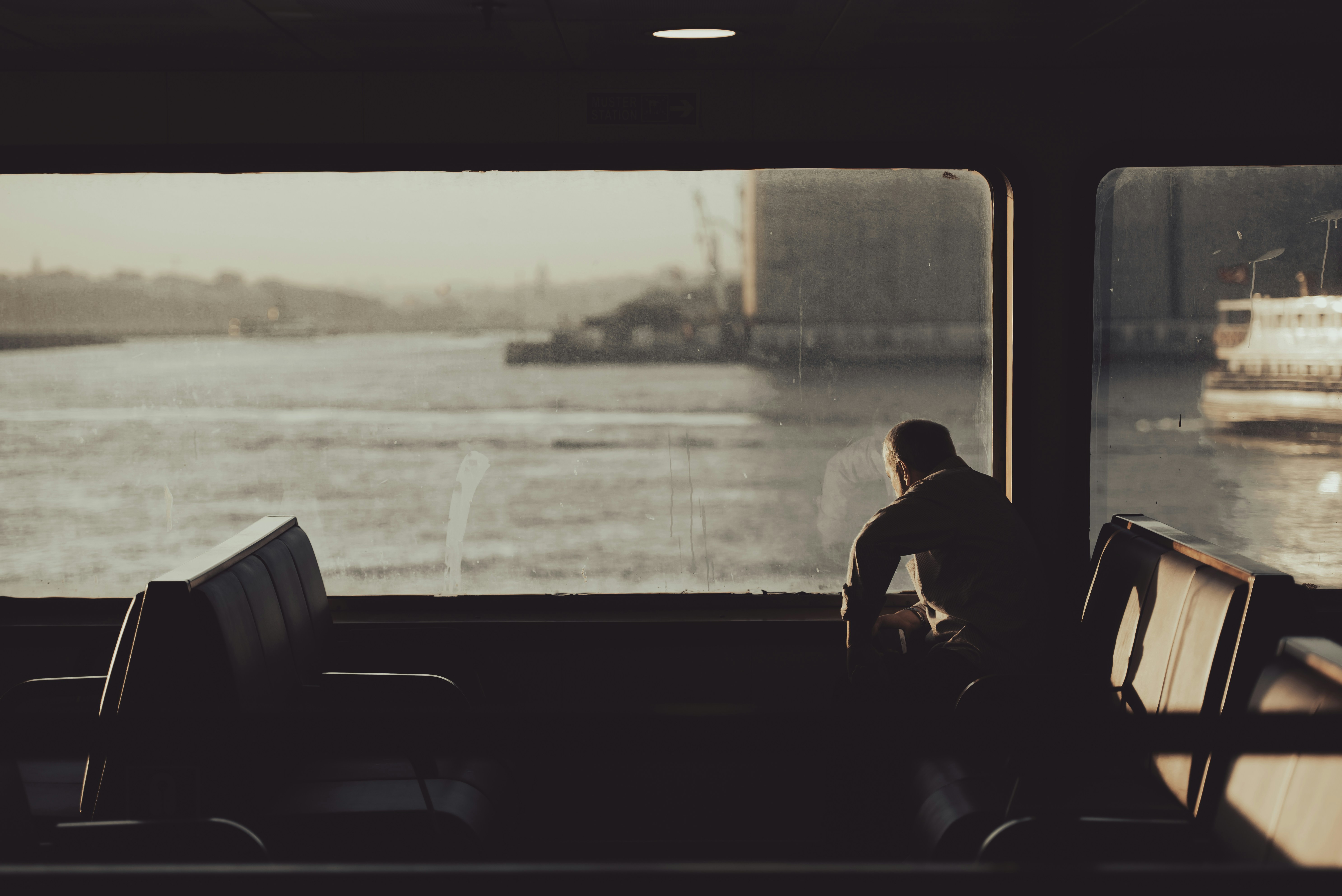 Passenger by the Window: Silhouette in a Quiet Harbor