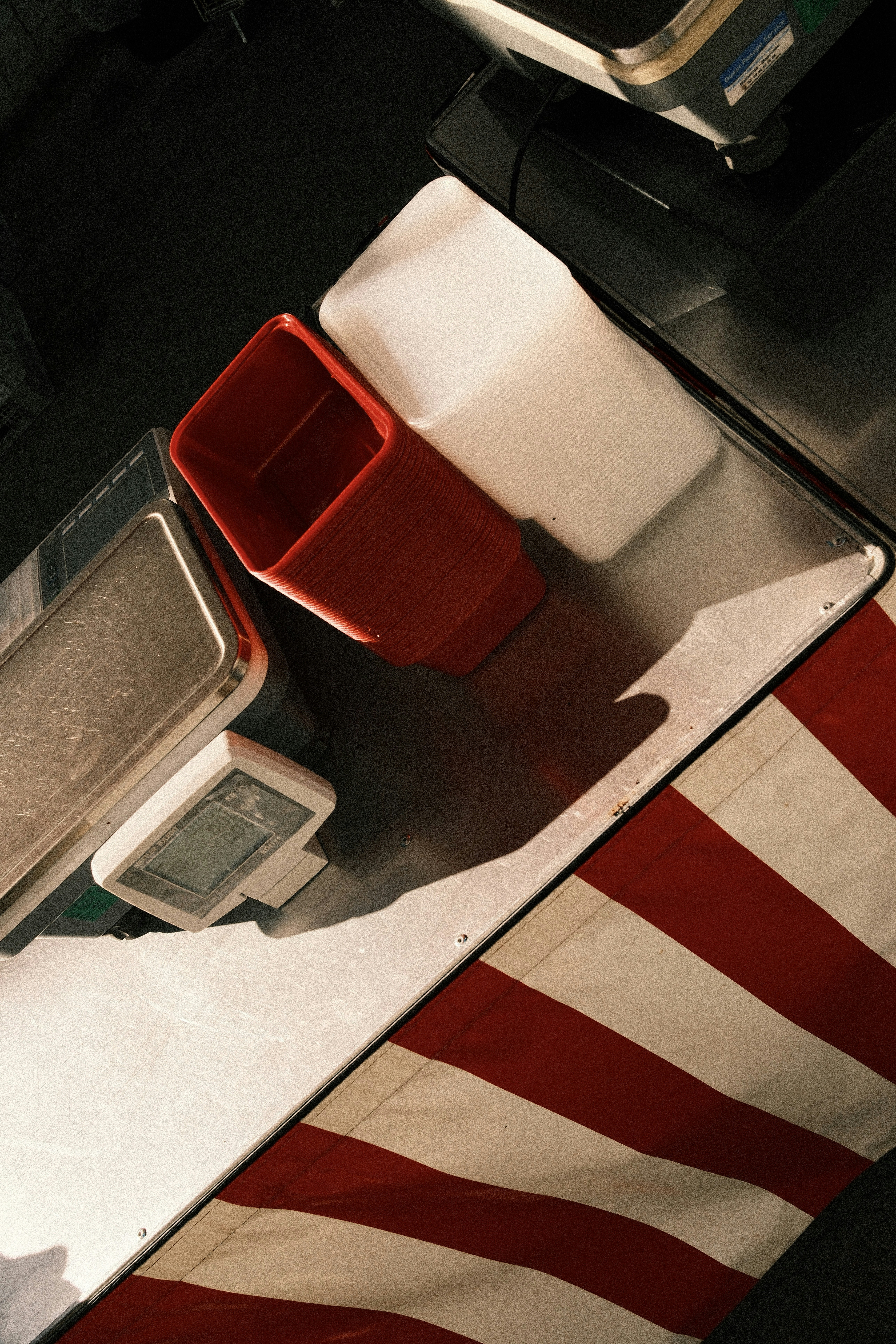 Red Waste Bin and Scales on a Stainless Counter in a Food Prep Area