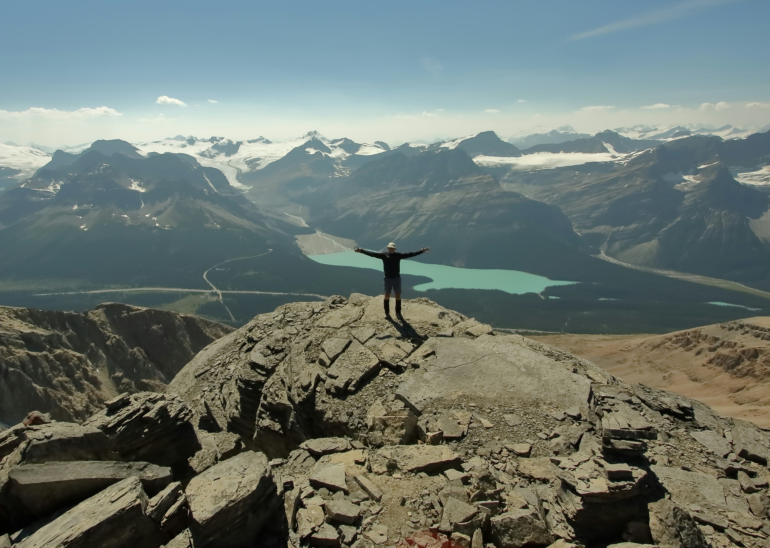 Ridge Summit: A Solo Stance Over Alpine Fjordscape